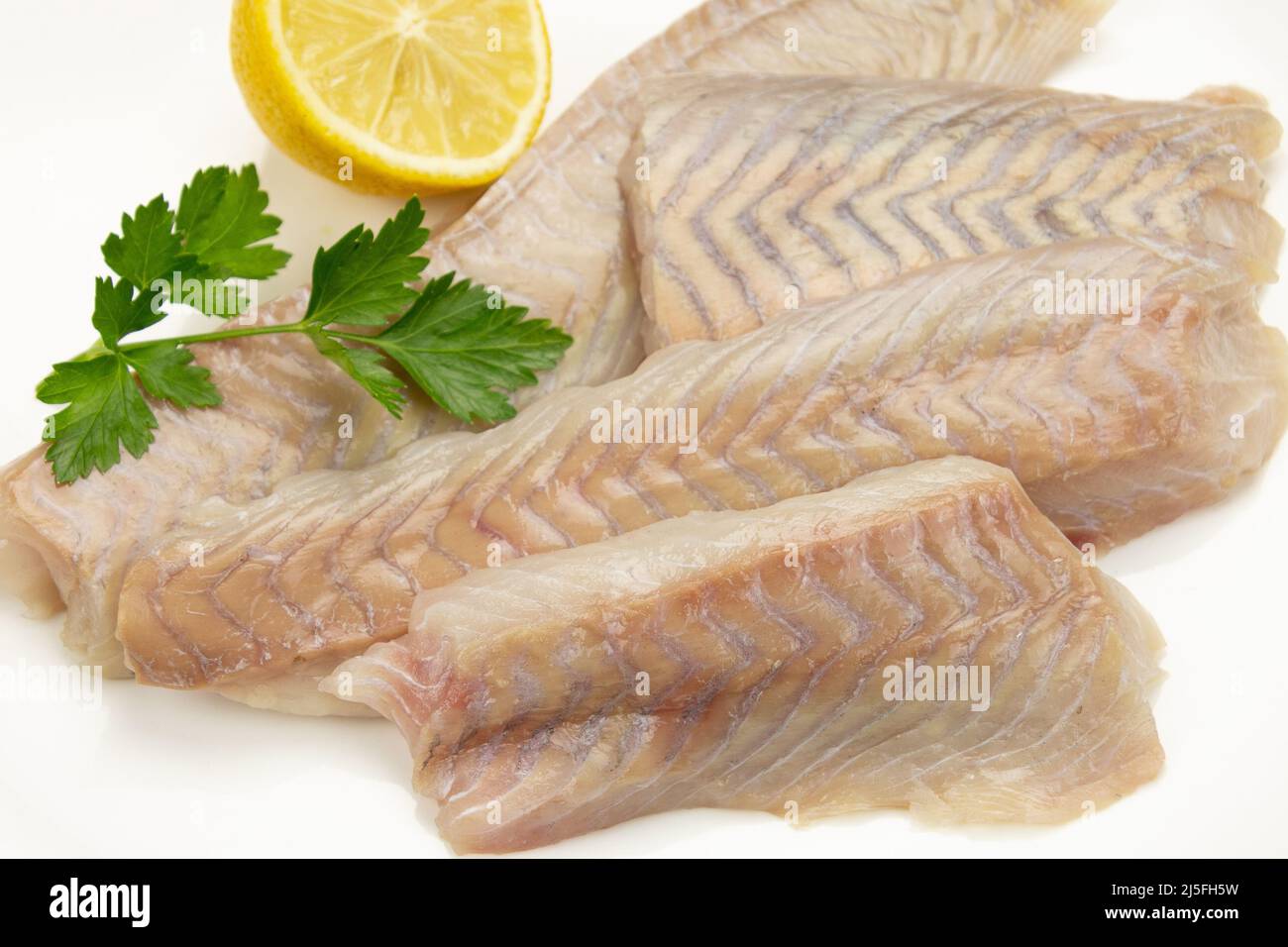raw fish fillet on a white background with lemon Stock Photo - Alamy