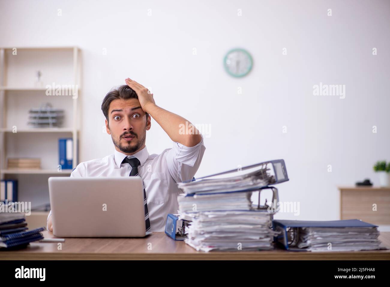 Young businessman employee and too much work in the office Stock Photo ...