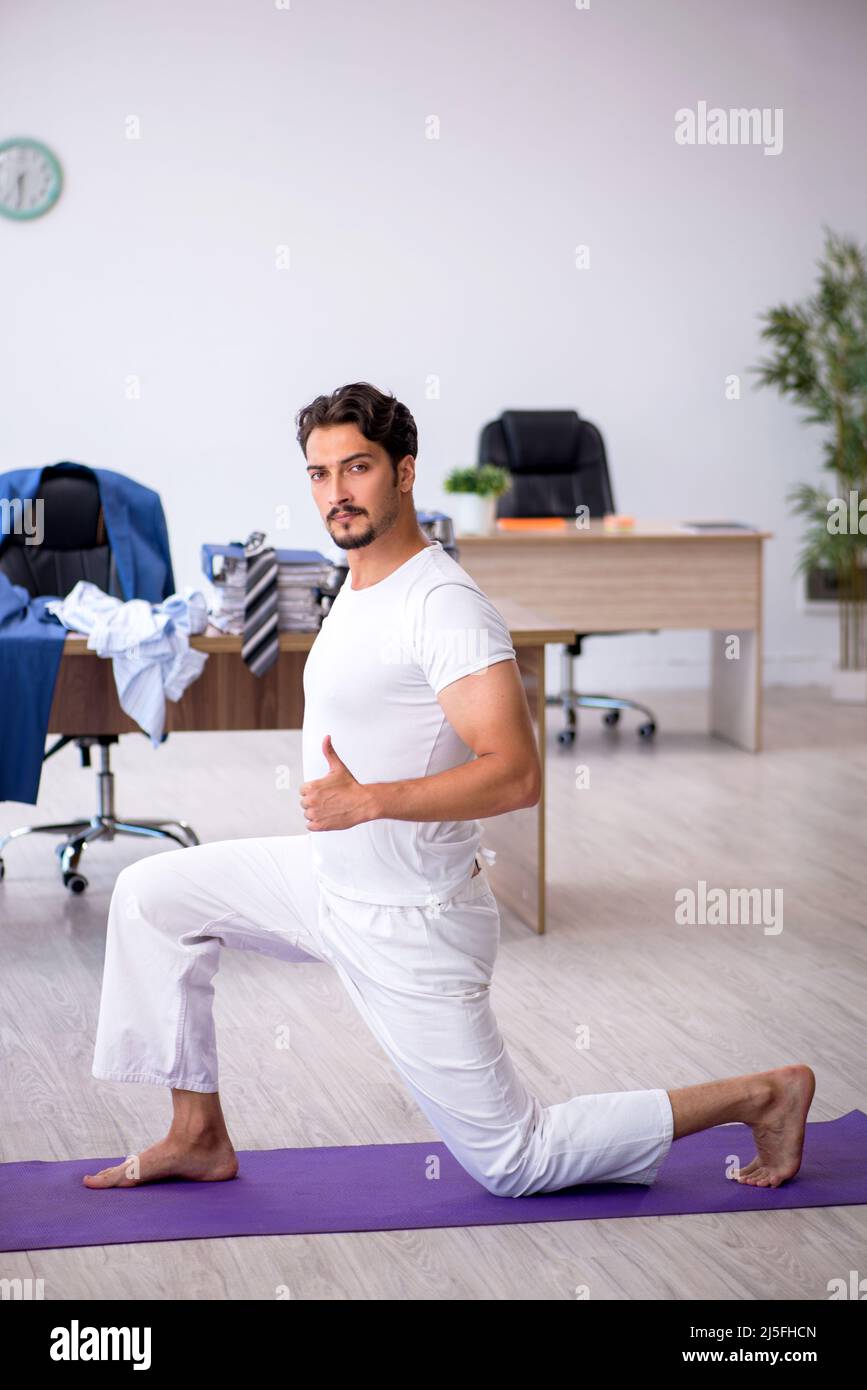 Young businessman employee doing sport exercises at workplace Stock ...