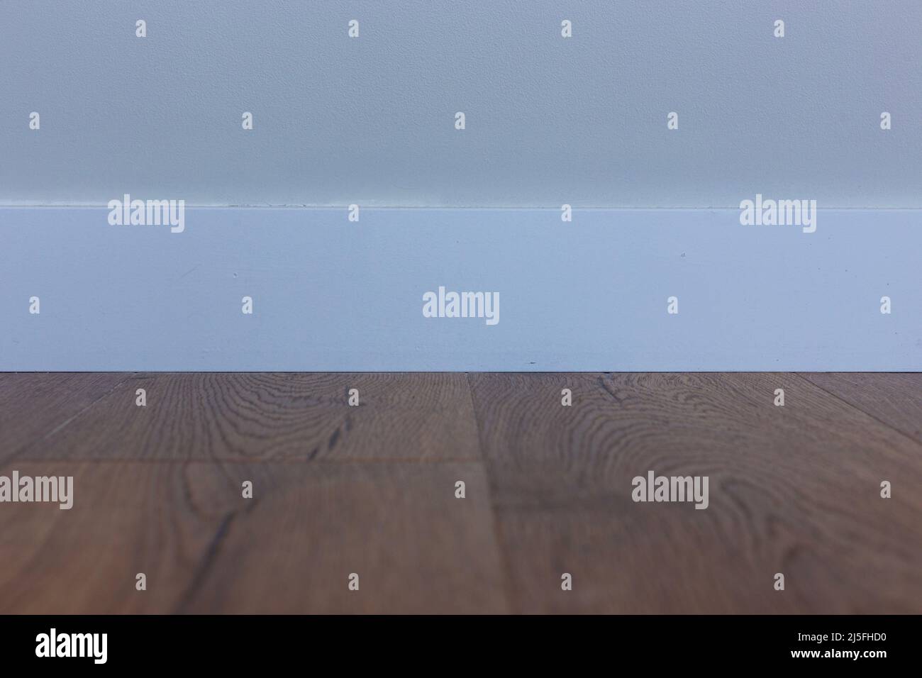 White baseboard, white wall and wood laminate Stock Photo - Alamy
