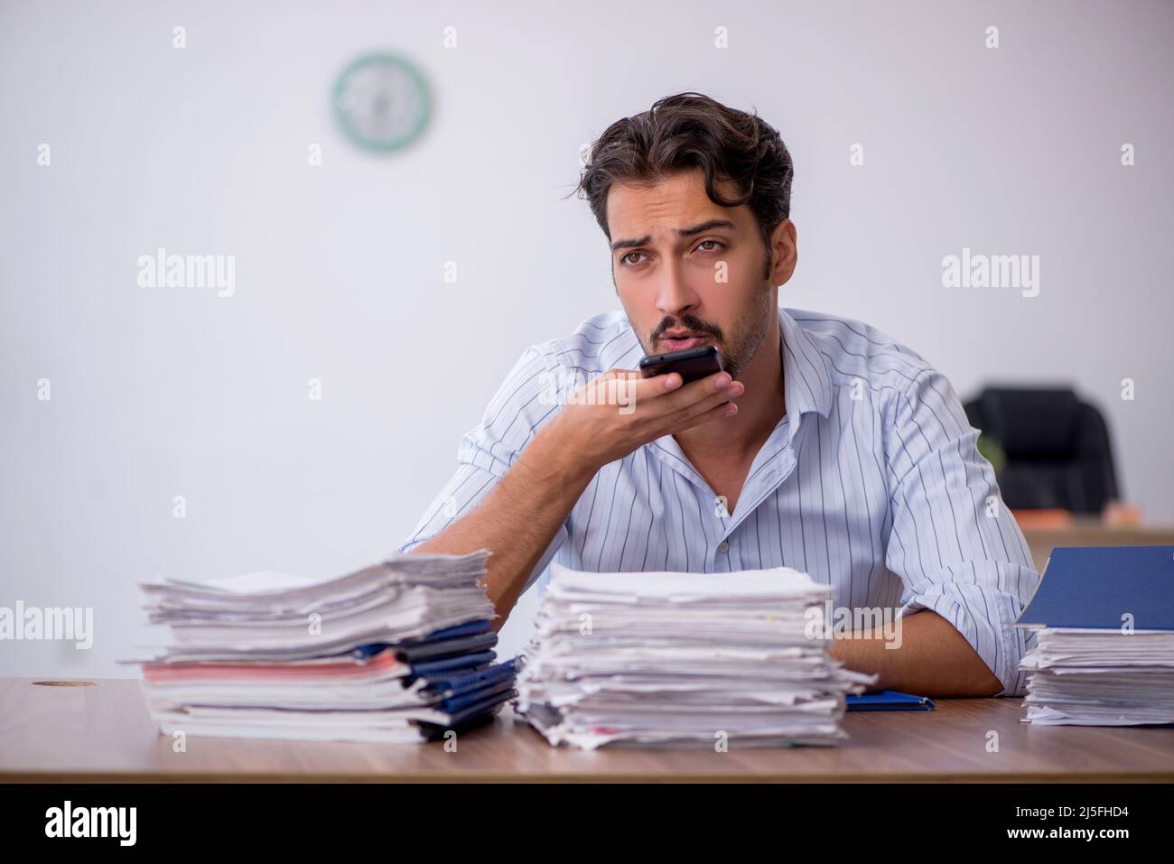 Young businessman employee unhappy with excessive work at workplace ...