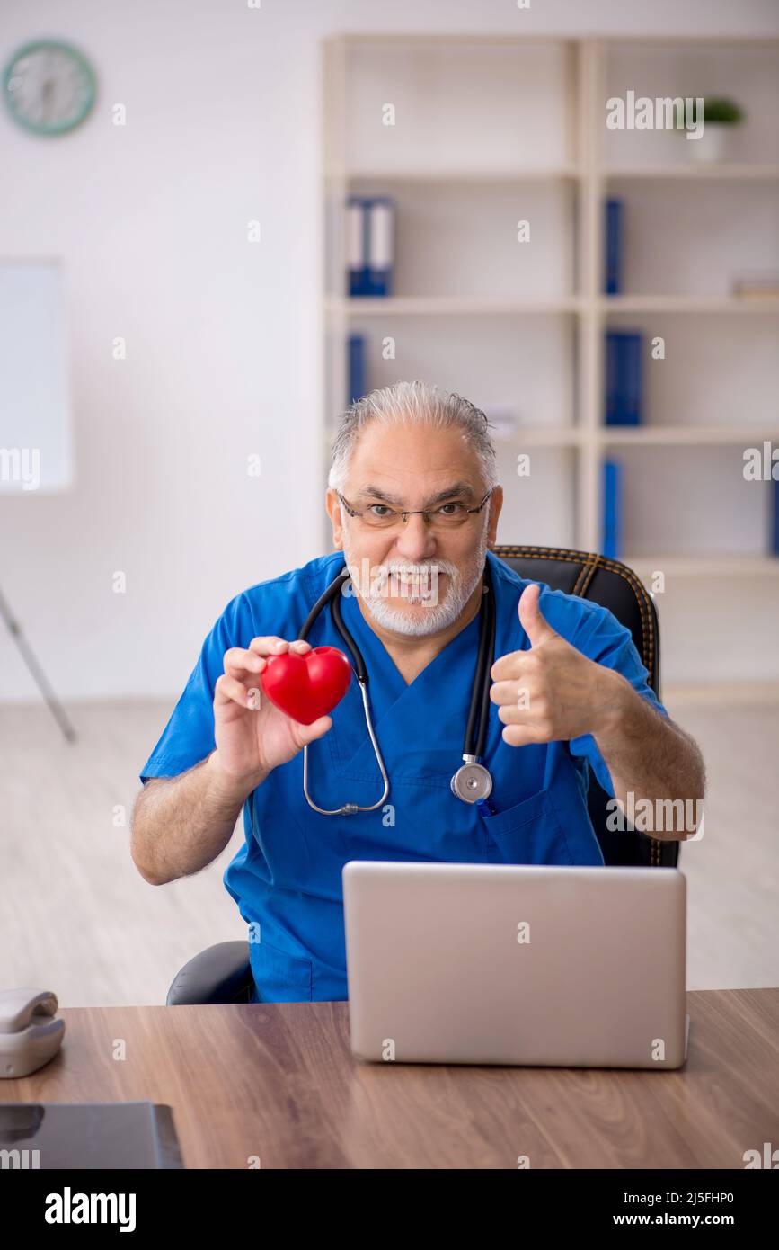 Old male doctor cardiologist working at the hospital Stock Photo - Alamy
