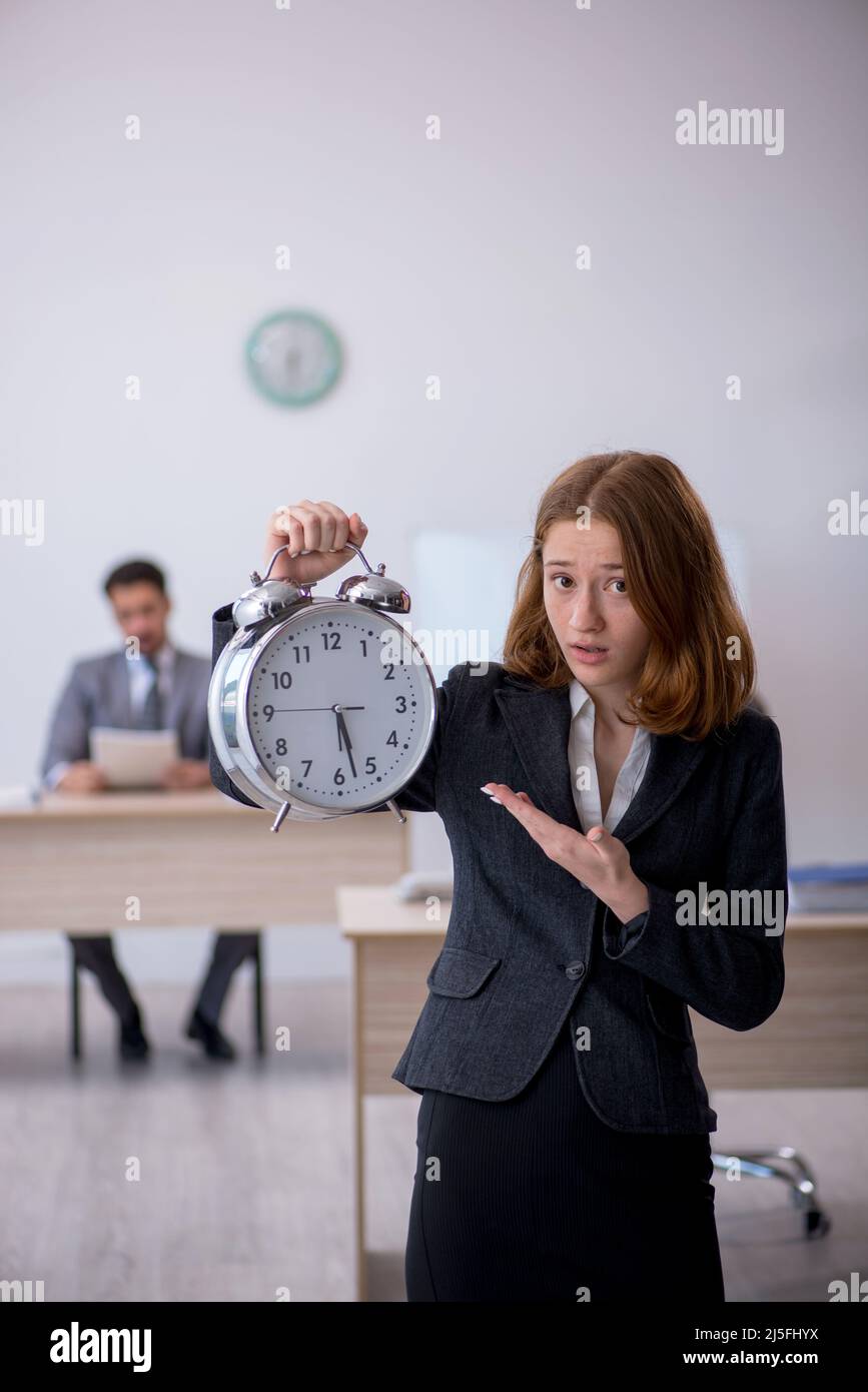 Two colleagues working in the workplace in time management concept ...