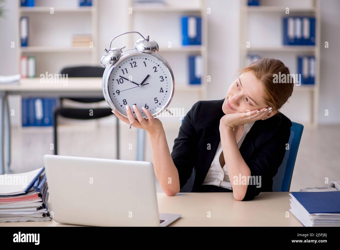 Female employee in time management concept Stock Photo - Alamy