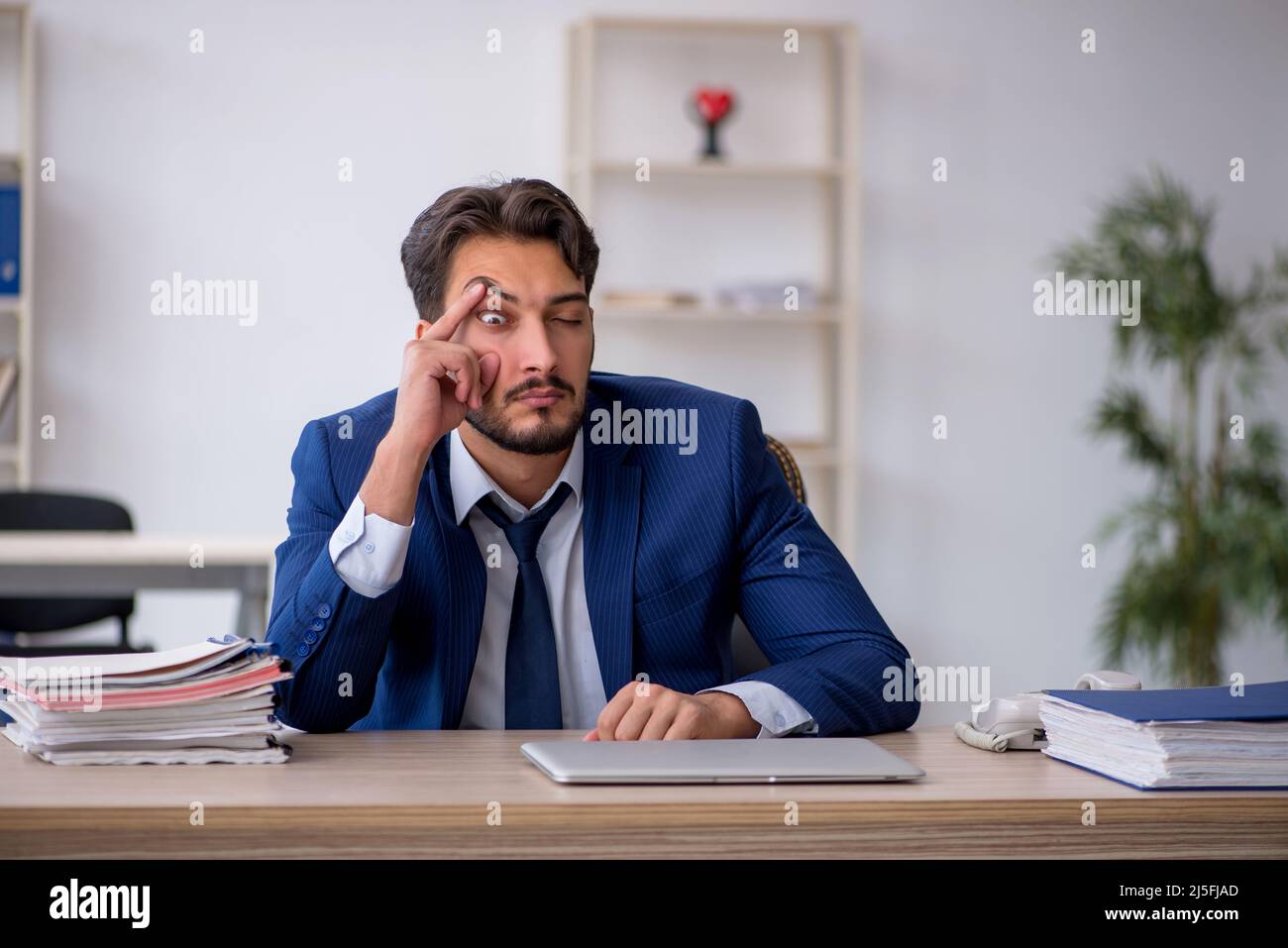 Young businessman employee extremely tired at workplace Stock Photo - Alamy