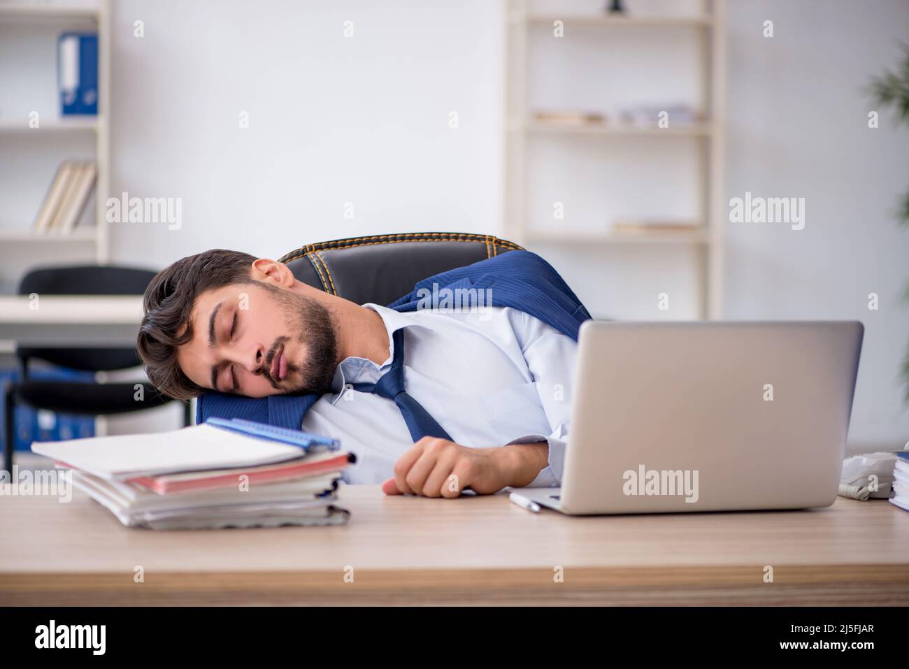 Young businessman employee extremely tired at workplace Stock Photo - Alamy