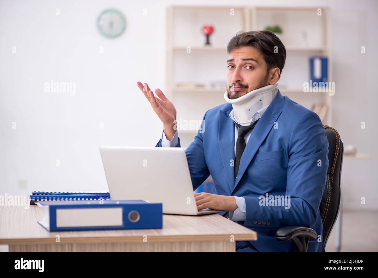 Young neck injured businessman employee at workplace Stock Photo - Alamy