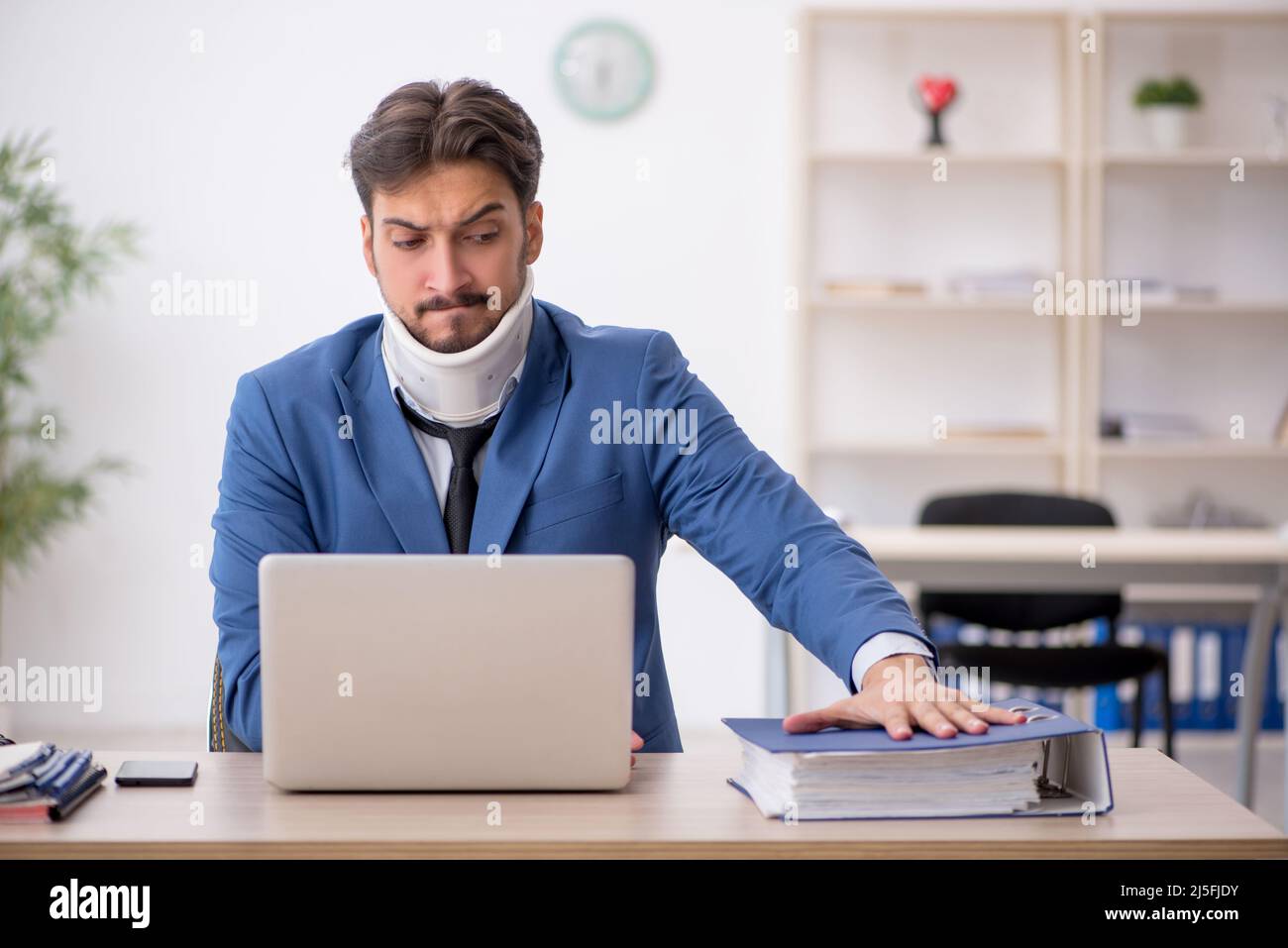 Young neck injured businessman employee at workplace Stock Photo - Alamy