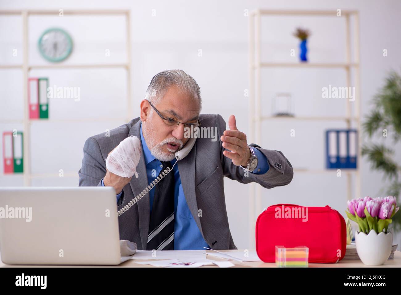 Old businessman employee cutting his hand at workplace Stock Photo - Alamy