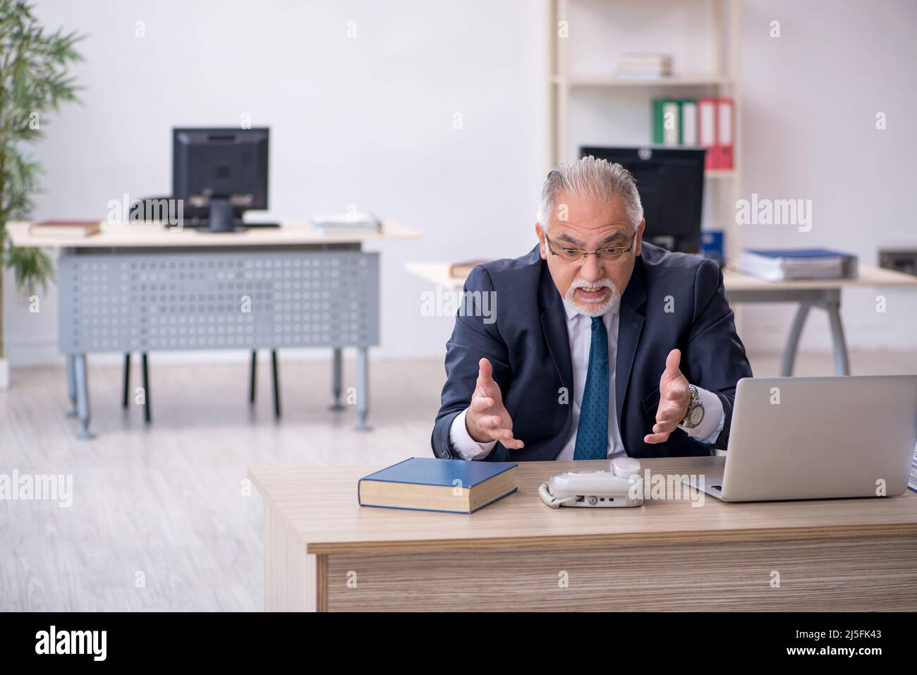 Old businessman employee speaking on the phone in the office Stock ...