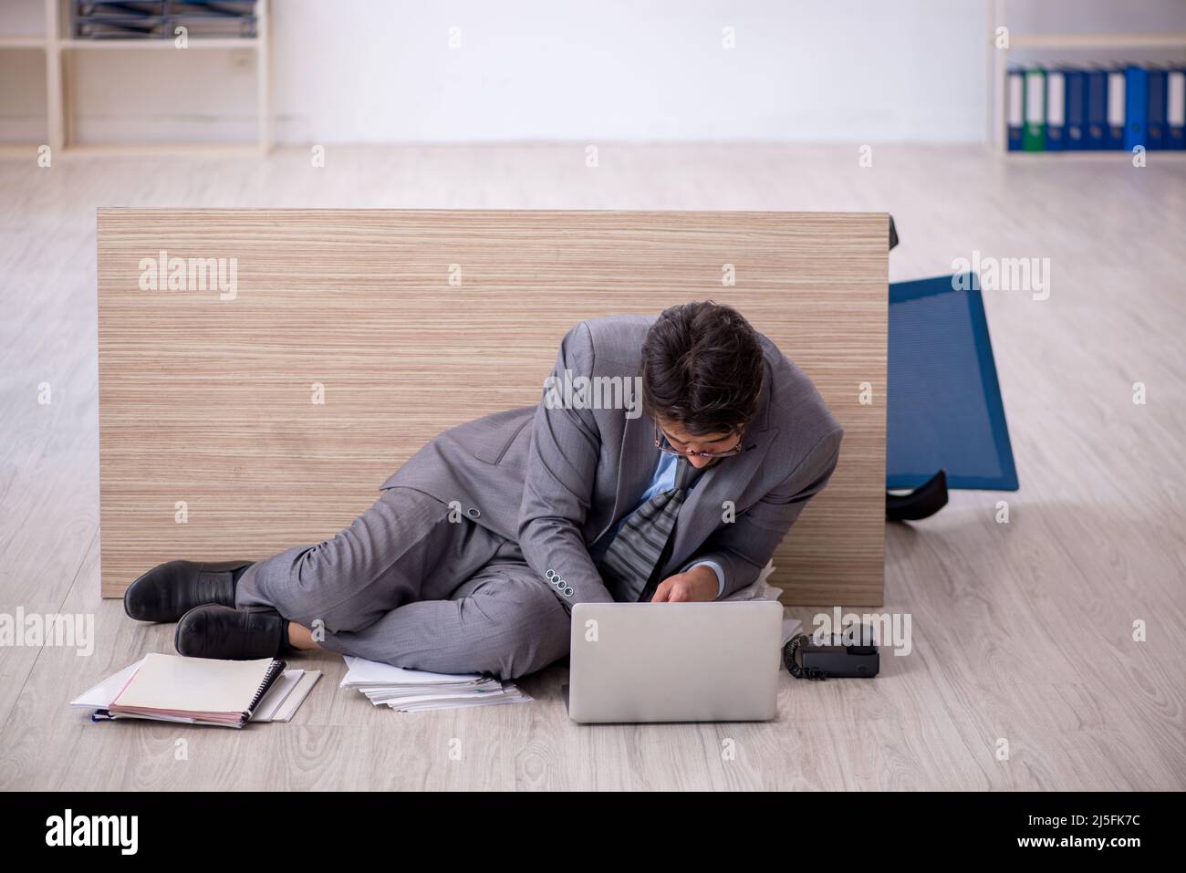 Young businessman employee working overtime at workplace Stock Photo ...