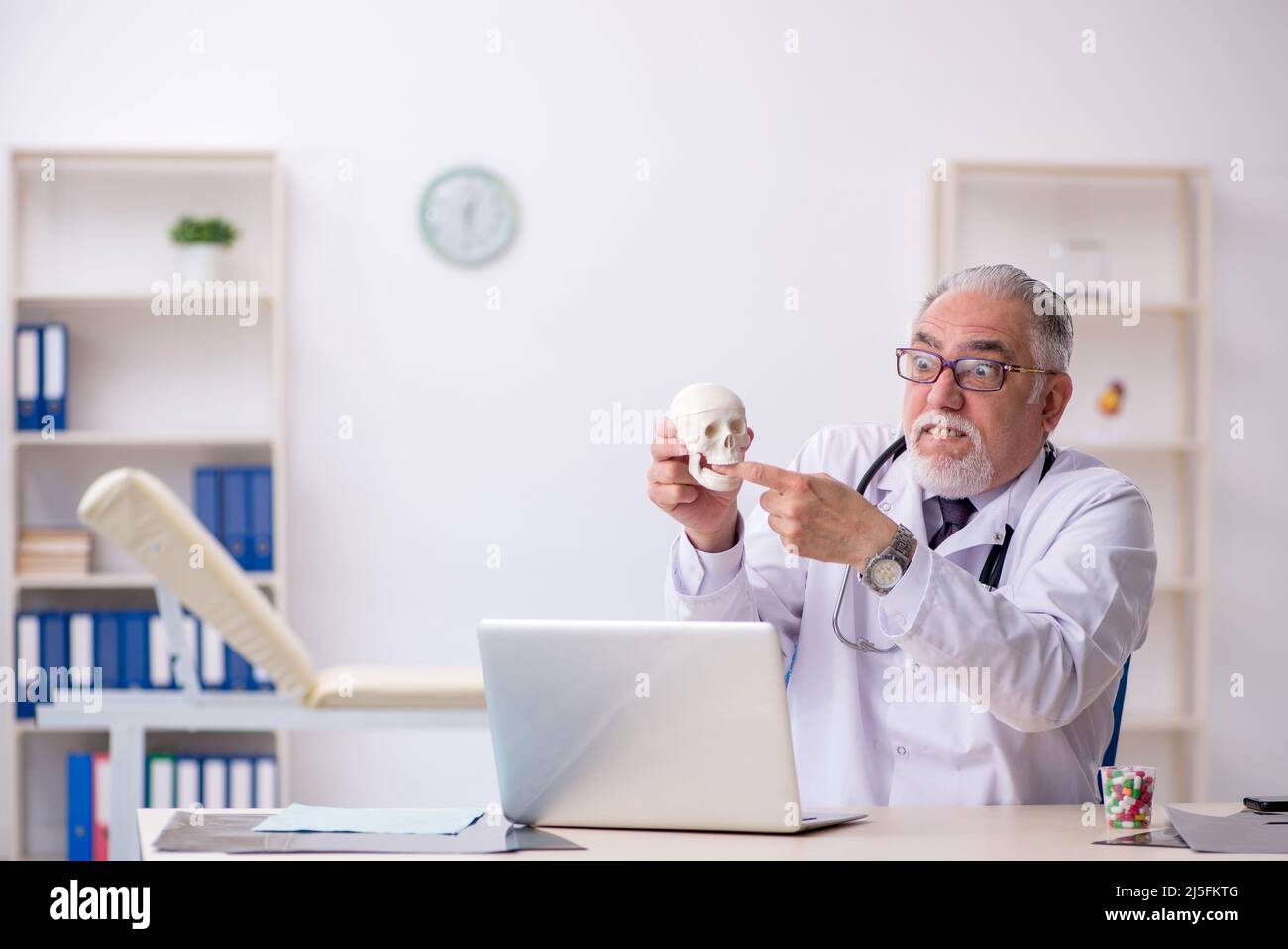 Old doctor demonstrating human skull Stock Photo - Alamy