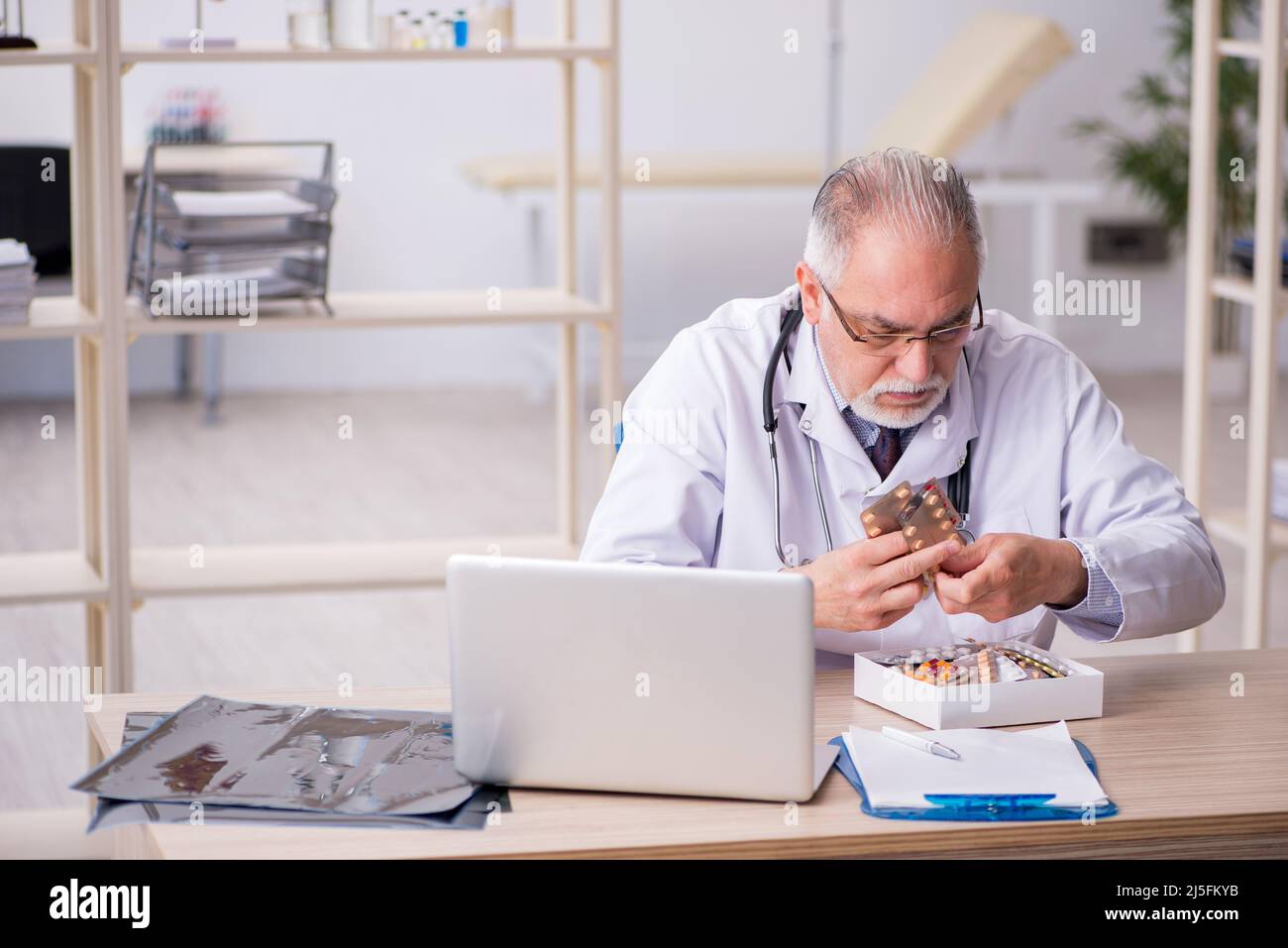 Old male doctor working at the hospital Stock Photo - Alamy