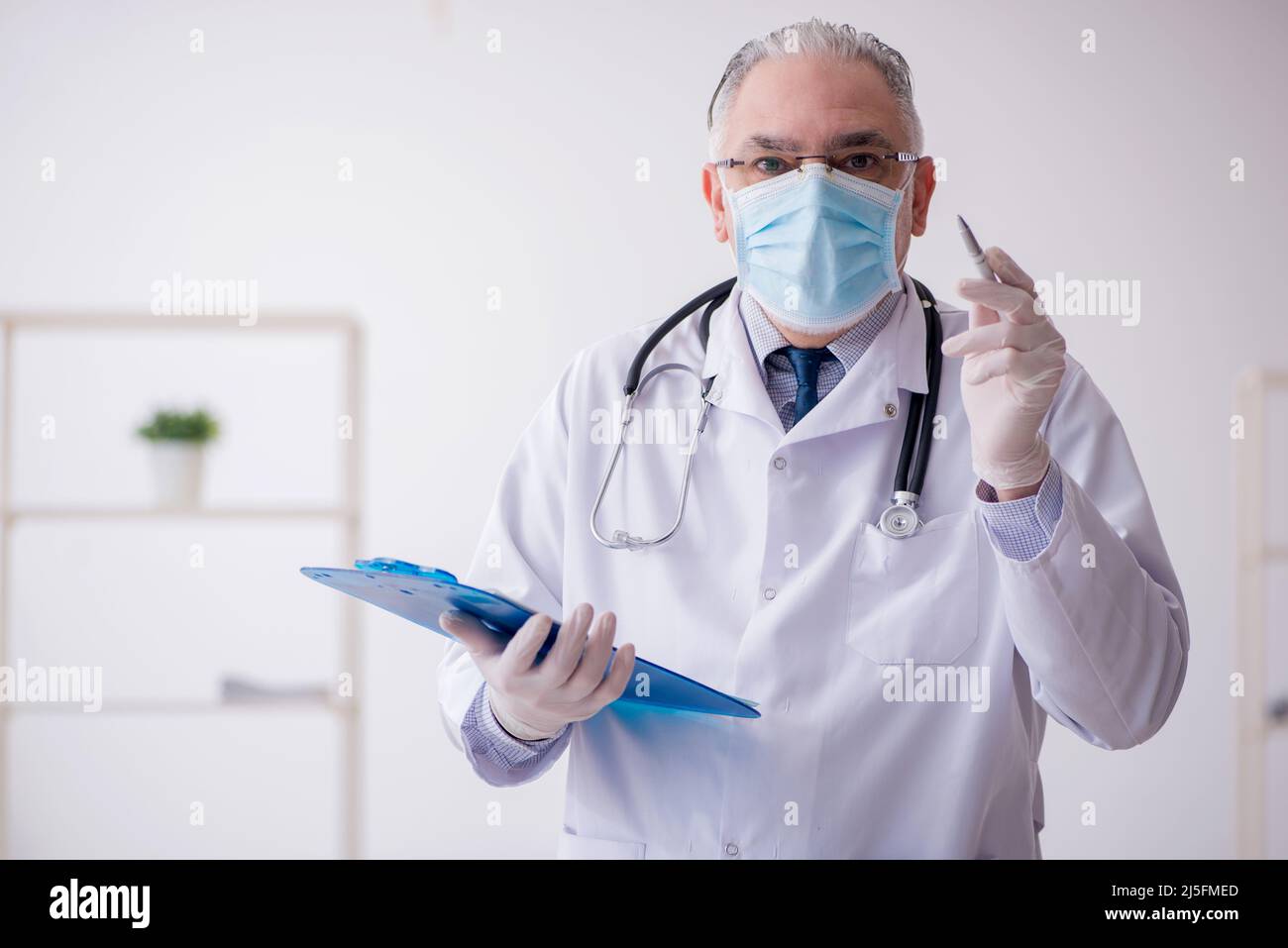 Old doctor working in the clinic Stock Photo - Alamy