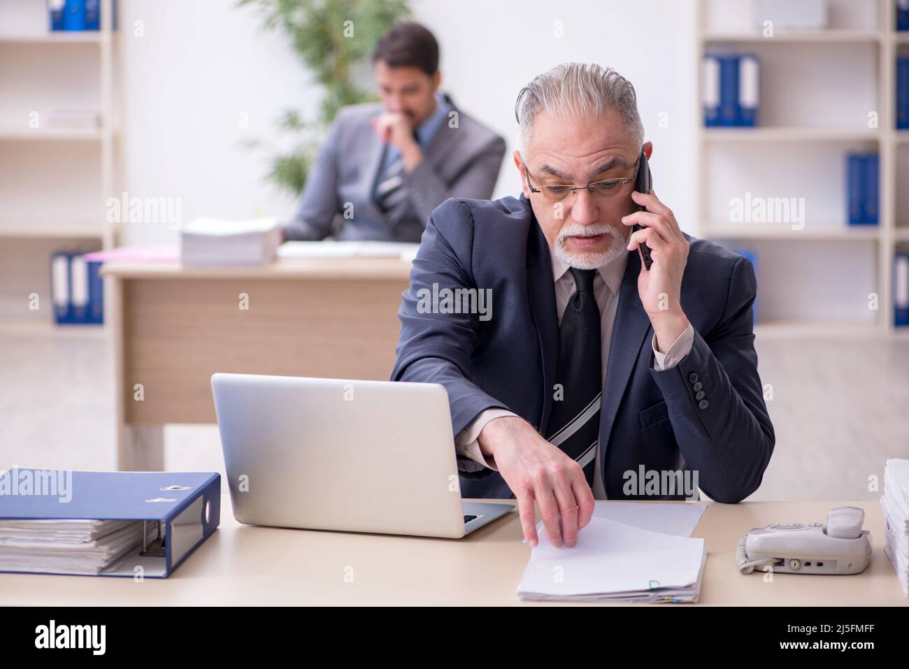 Two male employees working at workplace Stock Photo - Alamy