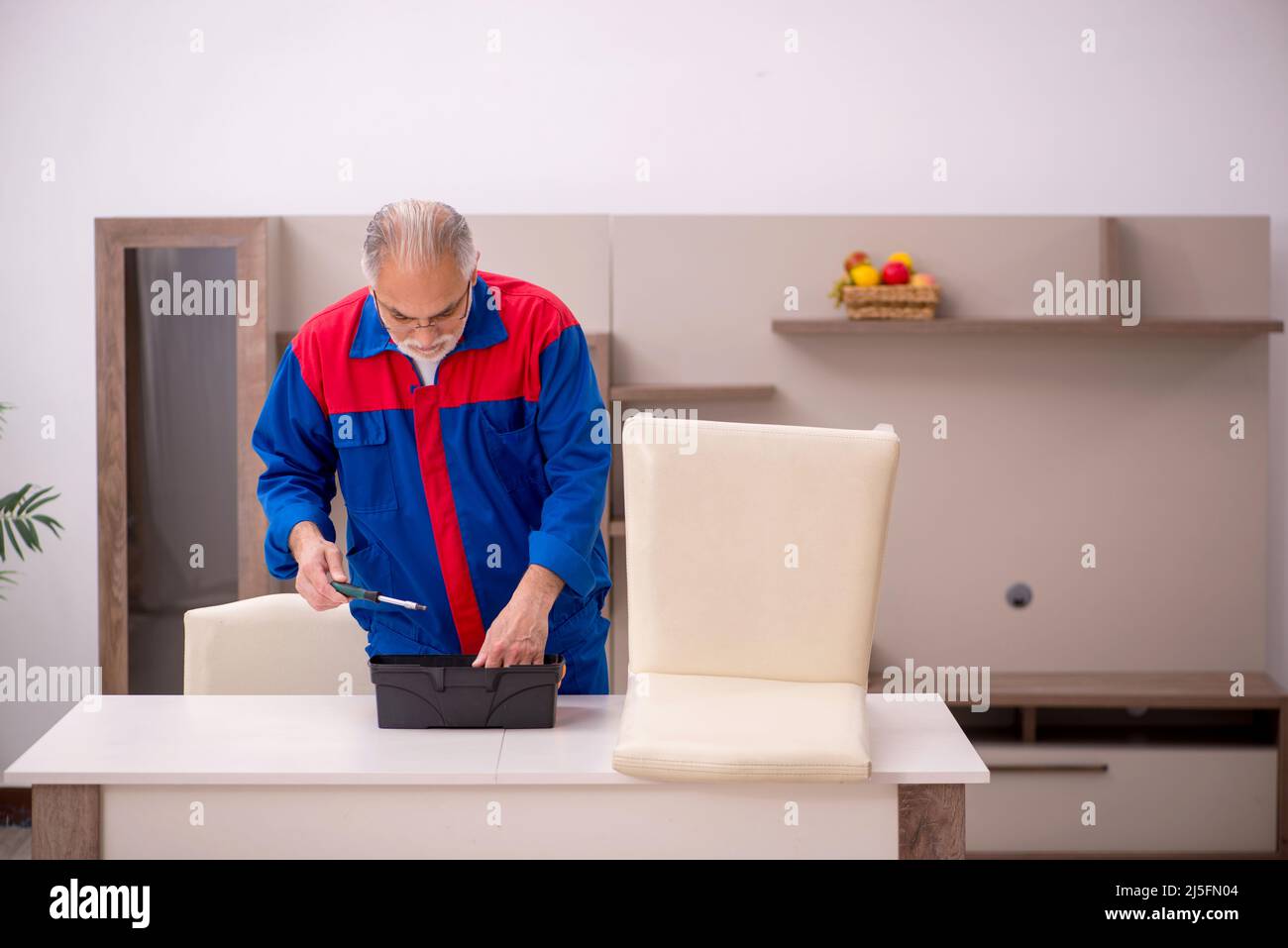 Old carpenter repairing chair at home Stock Photo - Alamy