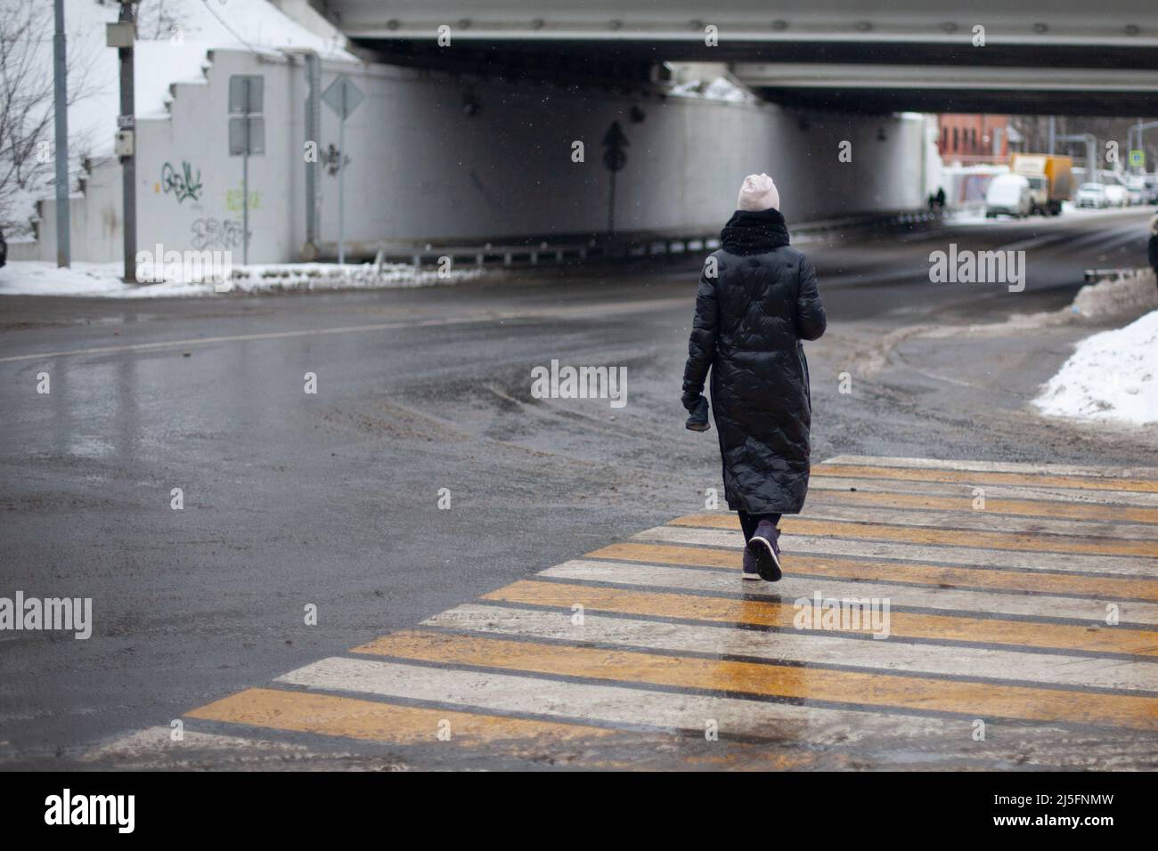 People in city are outside in winter. Pedestrian walks along path. Walk ...