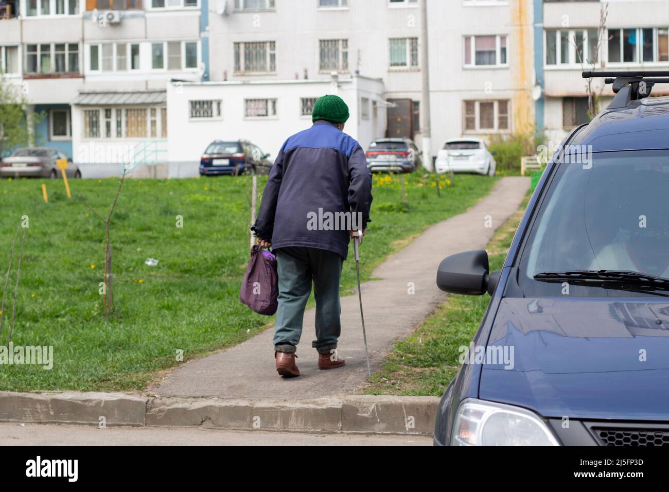 Pensioner With A Walking Stick An Old Man Walks Down The Street
