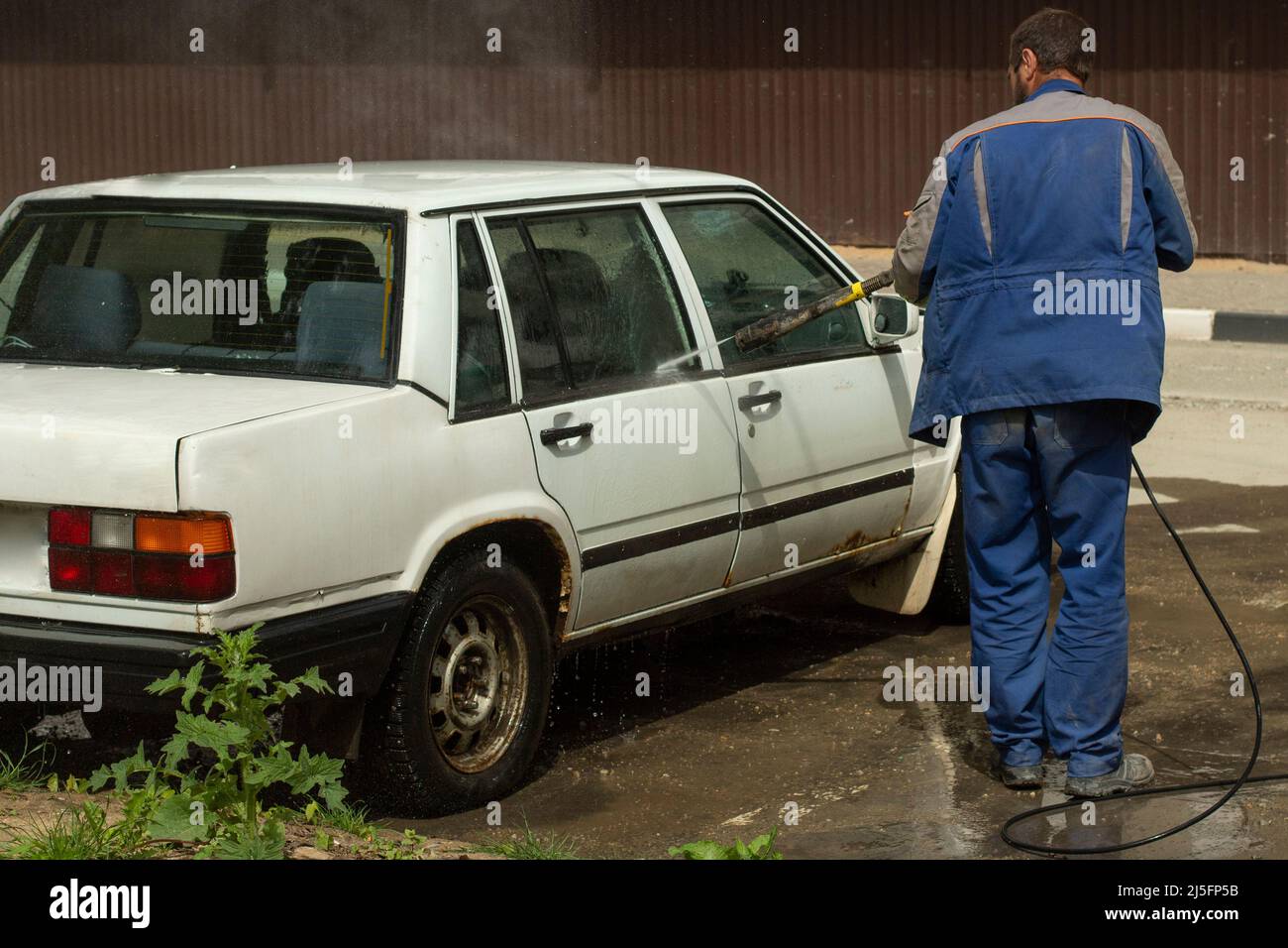 The car is washed at the car wash. Washing the car from dirt. High ...