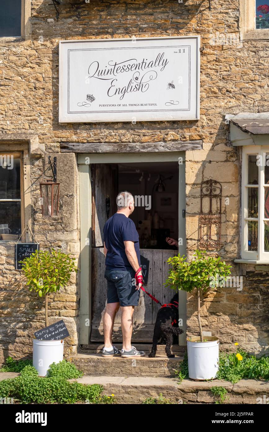 man and his dog wait outside a shop in an 18th Century terraced street ...