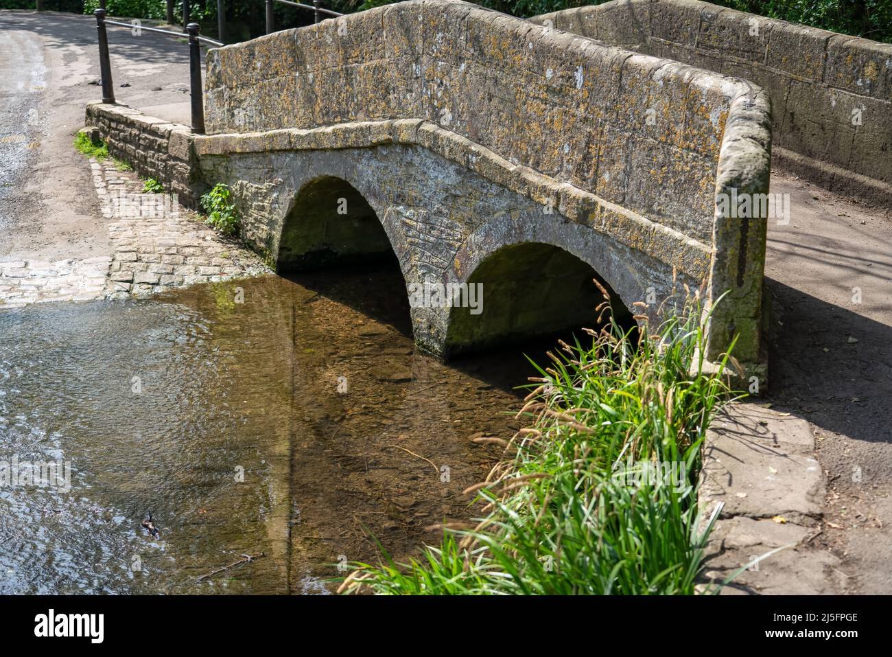 a stone built arch bridge over water stream in Lacock Wiltshire Stock ...