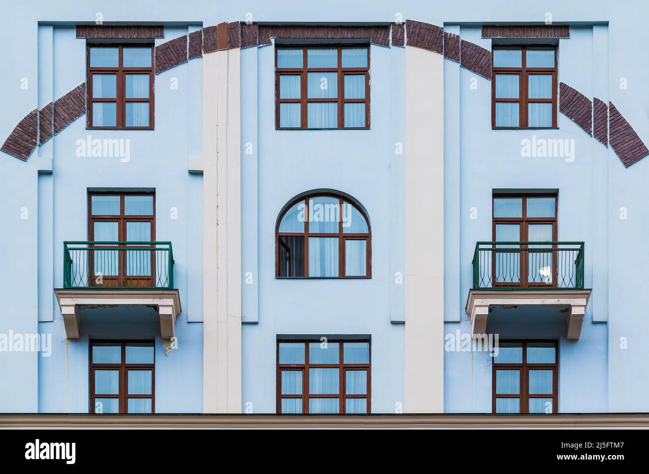 Two balconies and several windows in a row on the facade of the modern ...