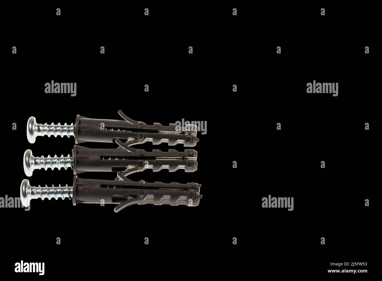 Close up view of screws screwed into black plastic screw caps isolated ...