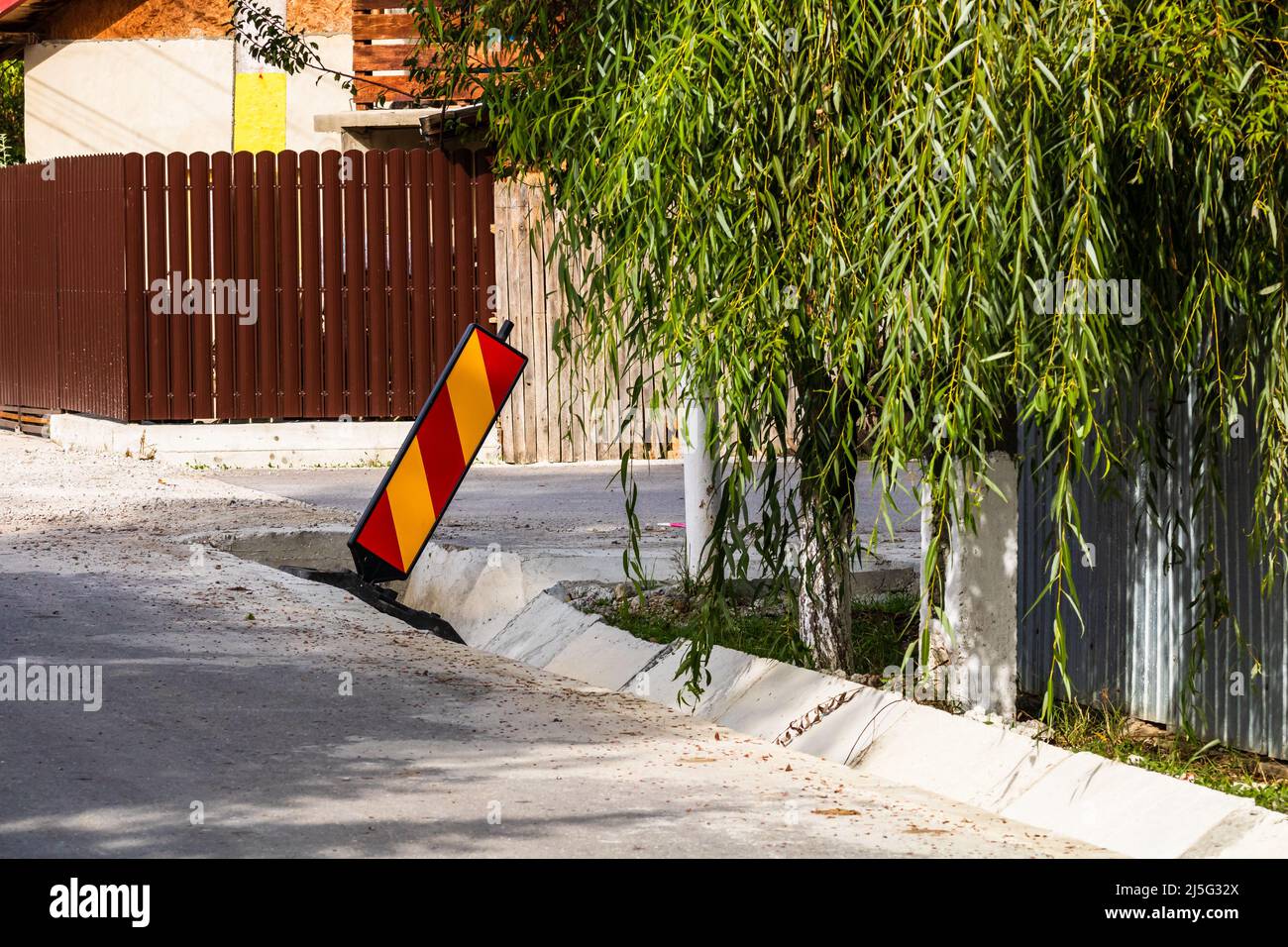 Reflective red and white striped warning road sign isolated in a ...