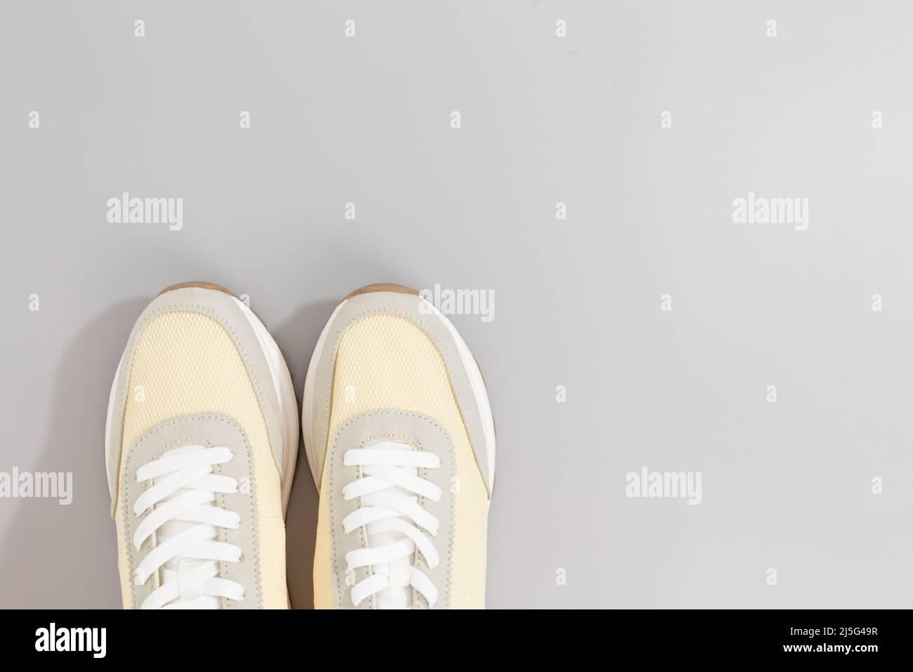 classic light color sneakers on grey background Stock Photo - Alamy