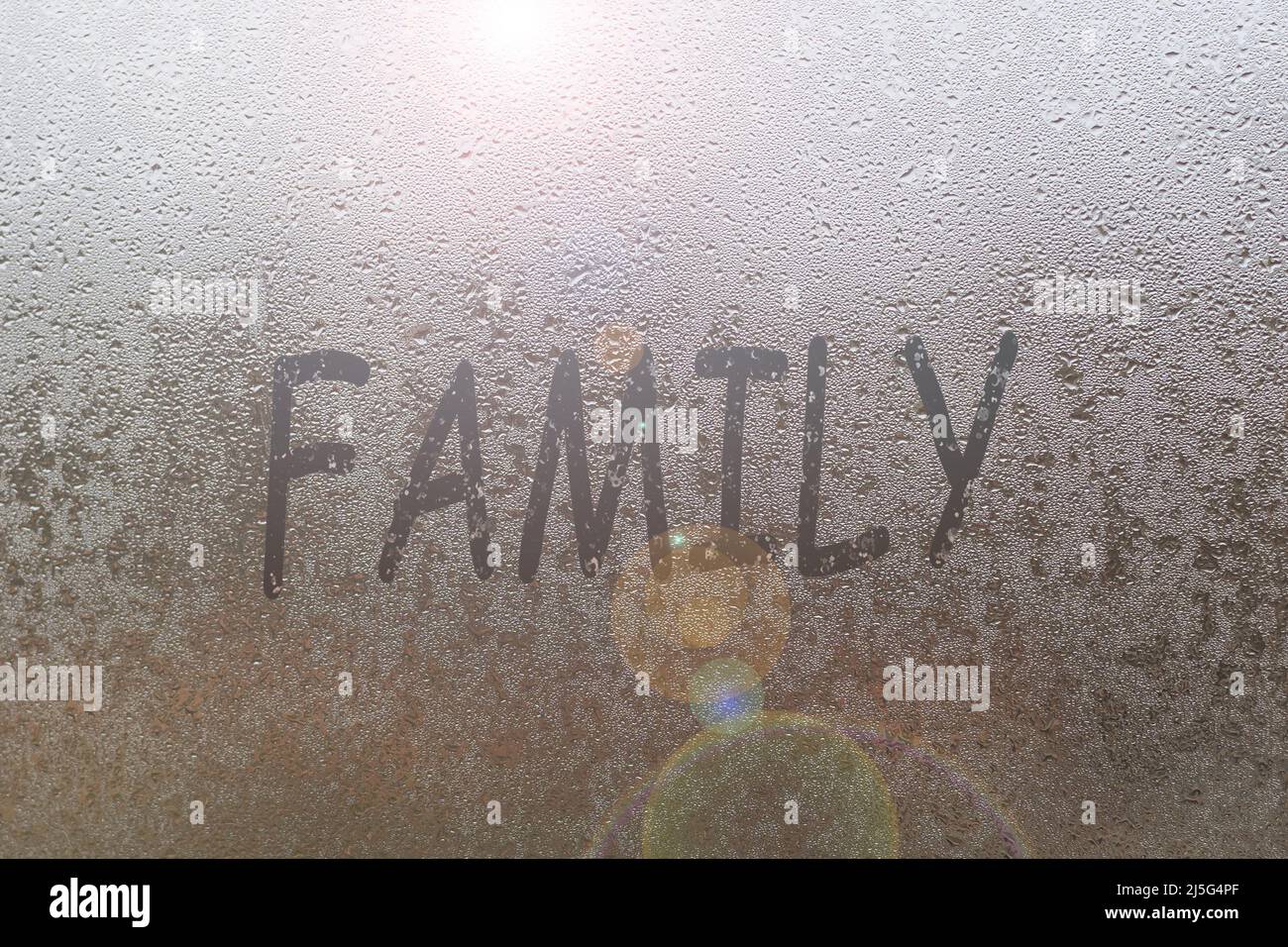 Foggy glass on window with written finger word family overcast wet ...