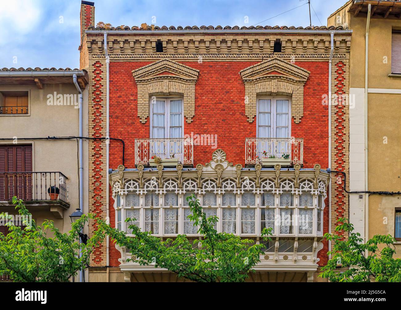 Ornate brickwork and enclosed glass balcony or veranda of an old house ...