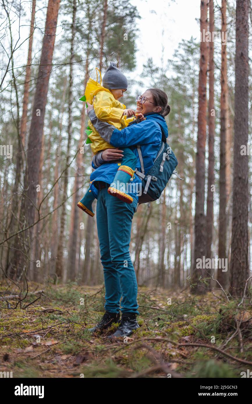 Happy family Mom and child walk in the forest after the rain in ...