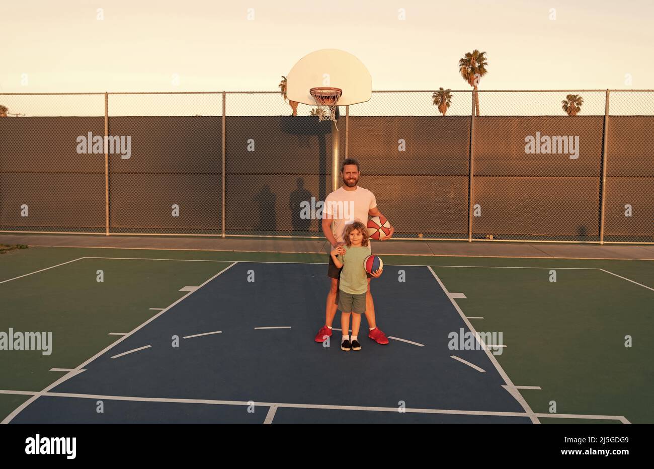 dad and kid boy play basketball. child hold sport ball. childhood and ...