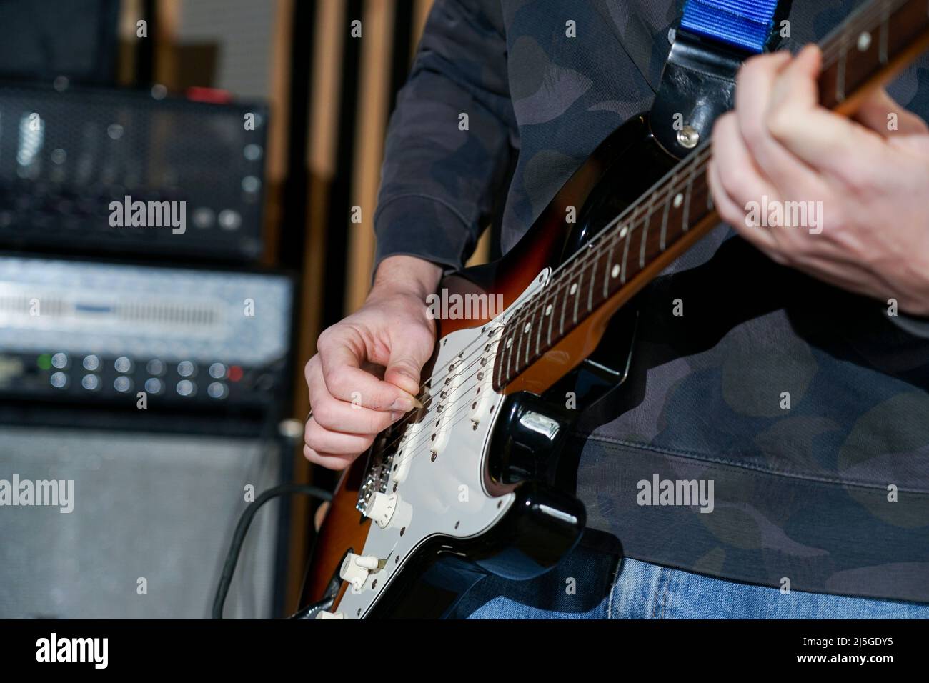 The guy plays the electric guitar to record the sound. He plays in the ...