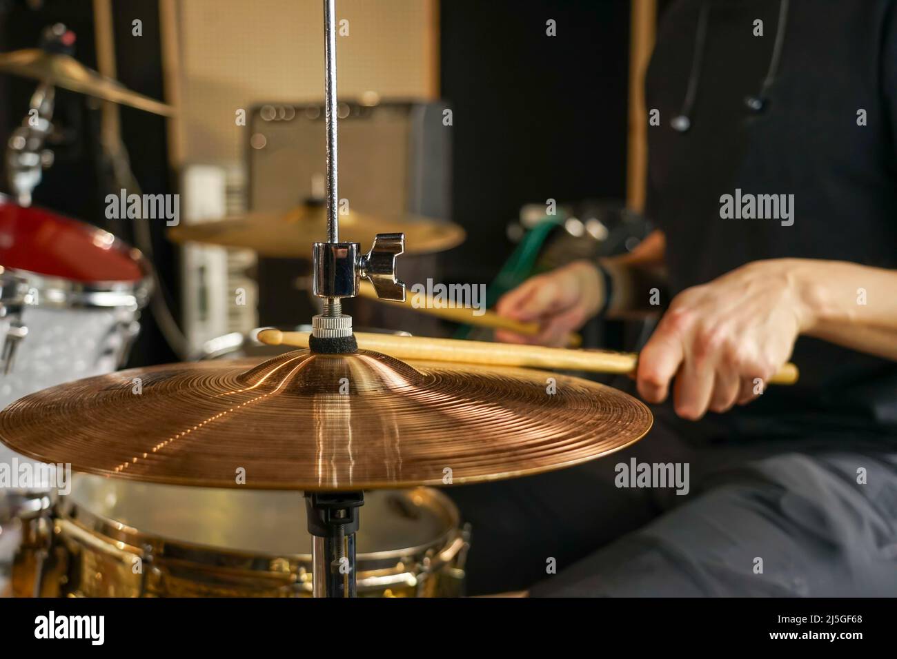 The guy plays the drums. The drummer sits at a drum set with drumsticks ...