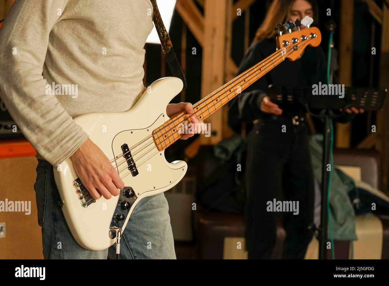 The guy plays the bass guitar. Bass guitarist holds an electric guitar ...