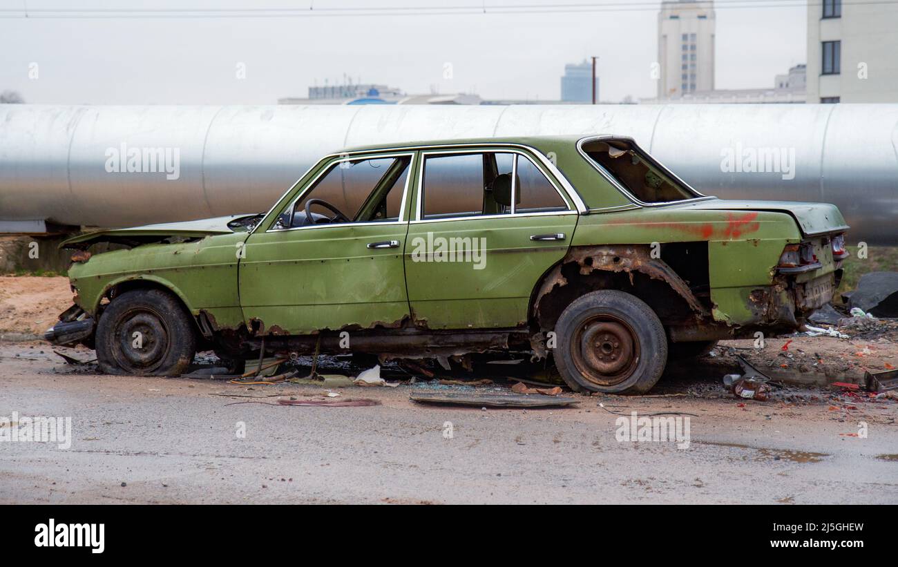 Completely wrecked green car. Side view Stock Photo - Alamy