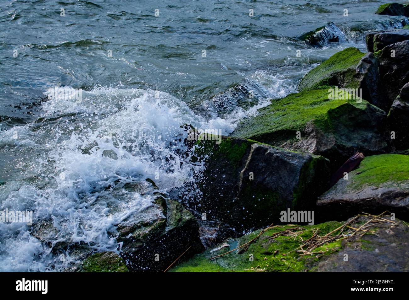 Waves splashing on the stones at the beach Stock Photo - Alamy