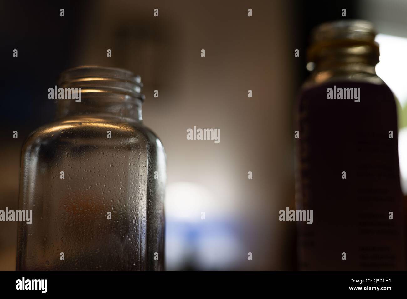 Bottle in dimly lit room empty of all liquid Stock Photo - Alamy