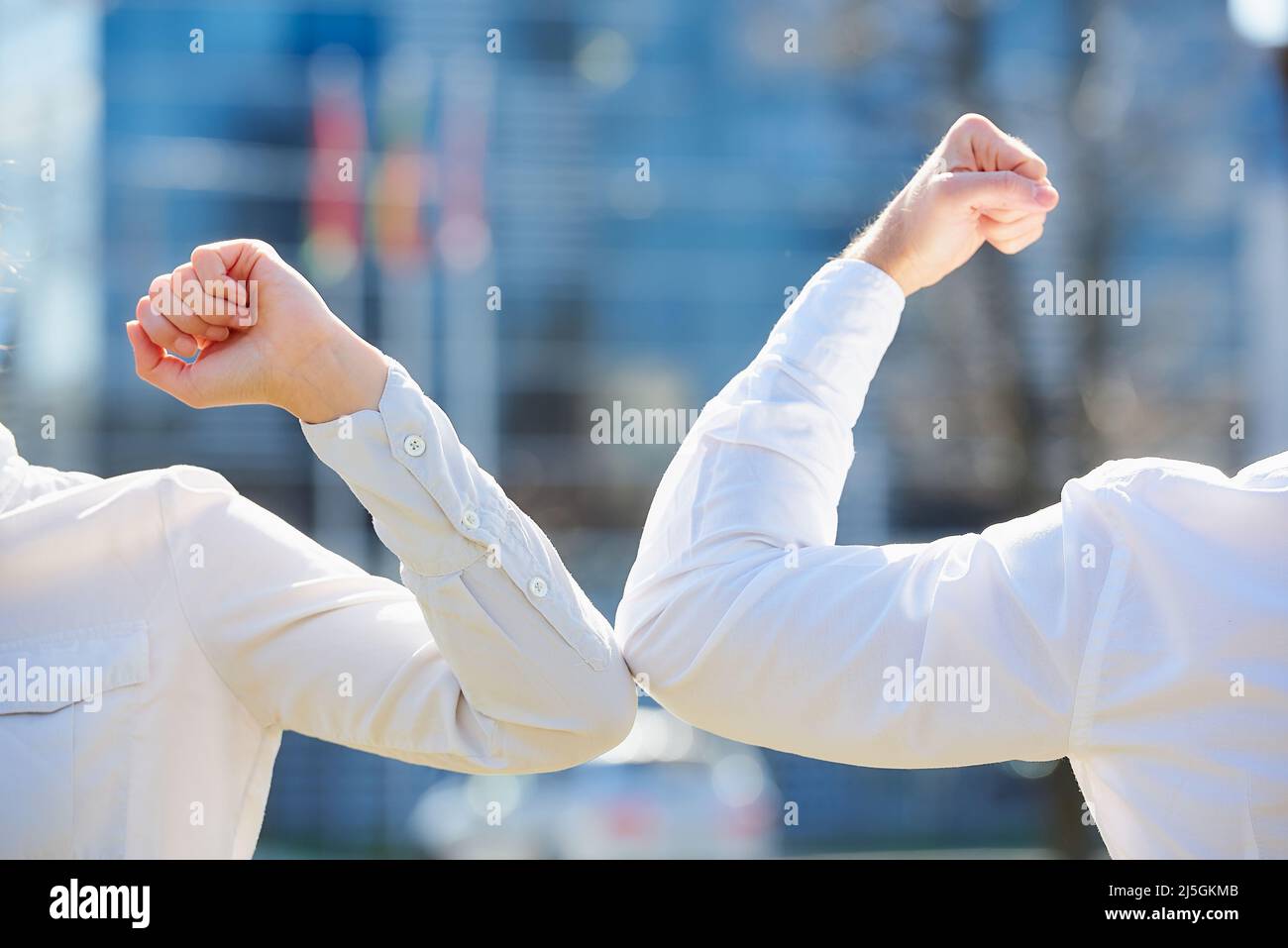 Instead of greeting with hug or handshake man and woman bump elbows on ...