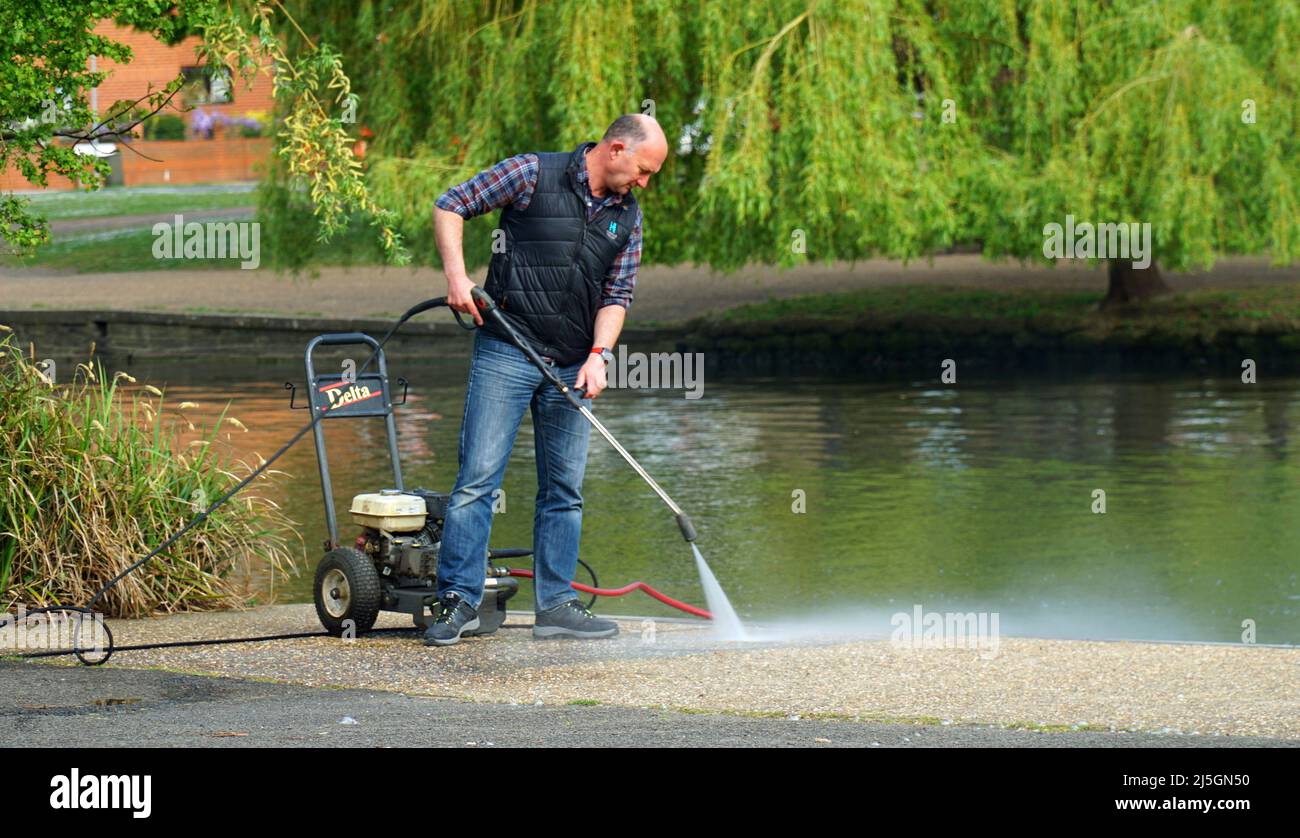 Man jet washing riverside paved area Stock Photo - Alamy