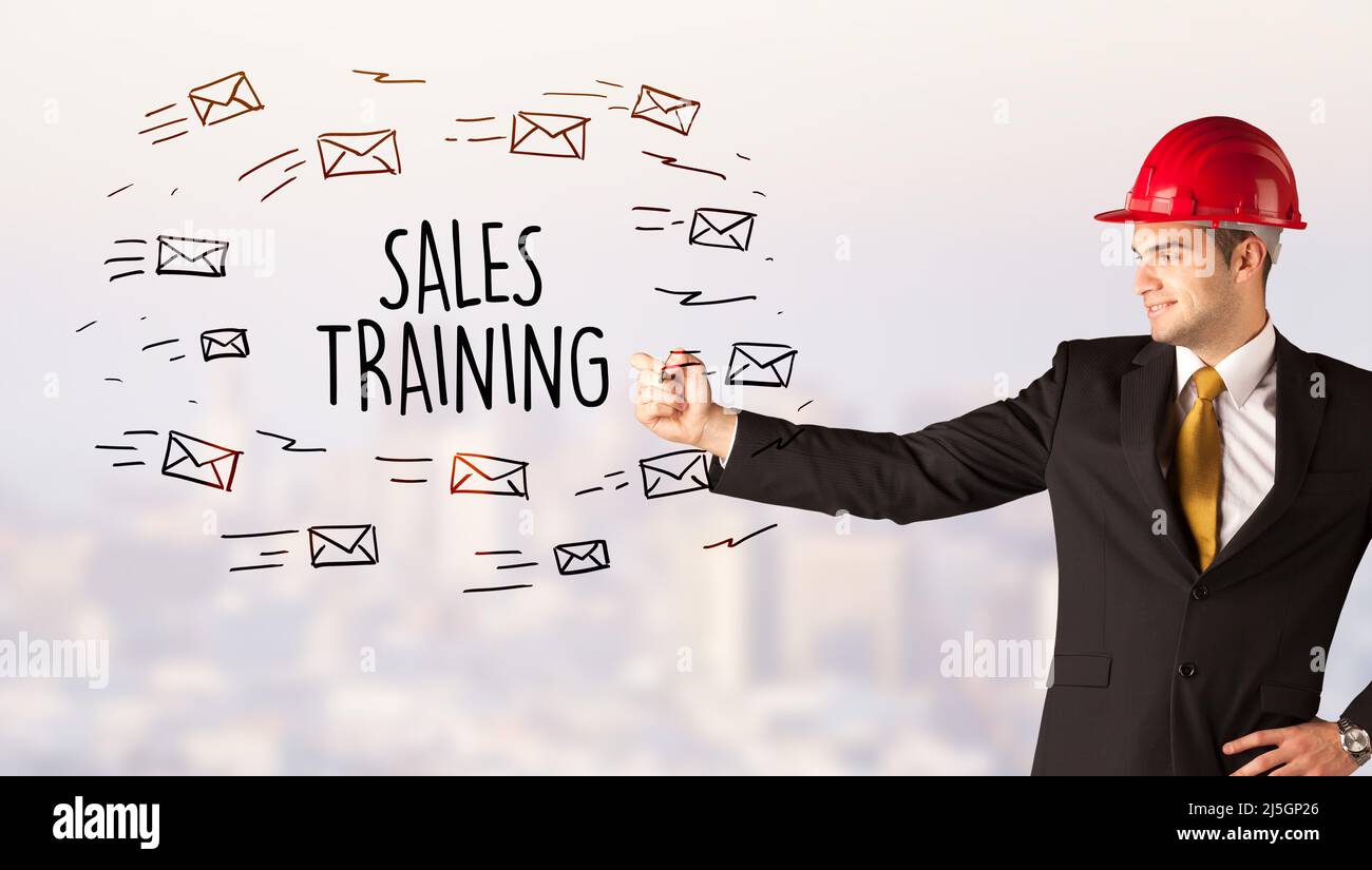 Young businessman with helmet drawing sale sign Stock Photo - Alamy