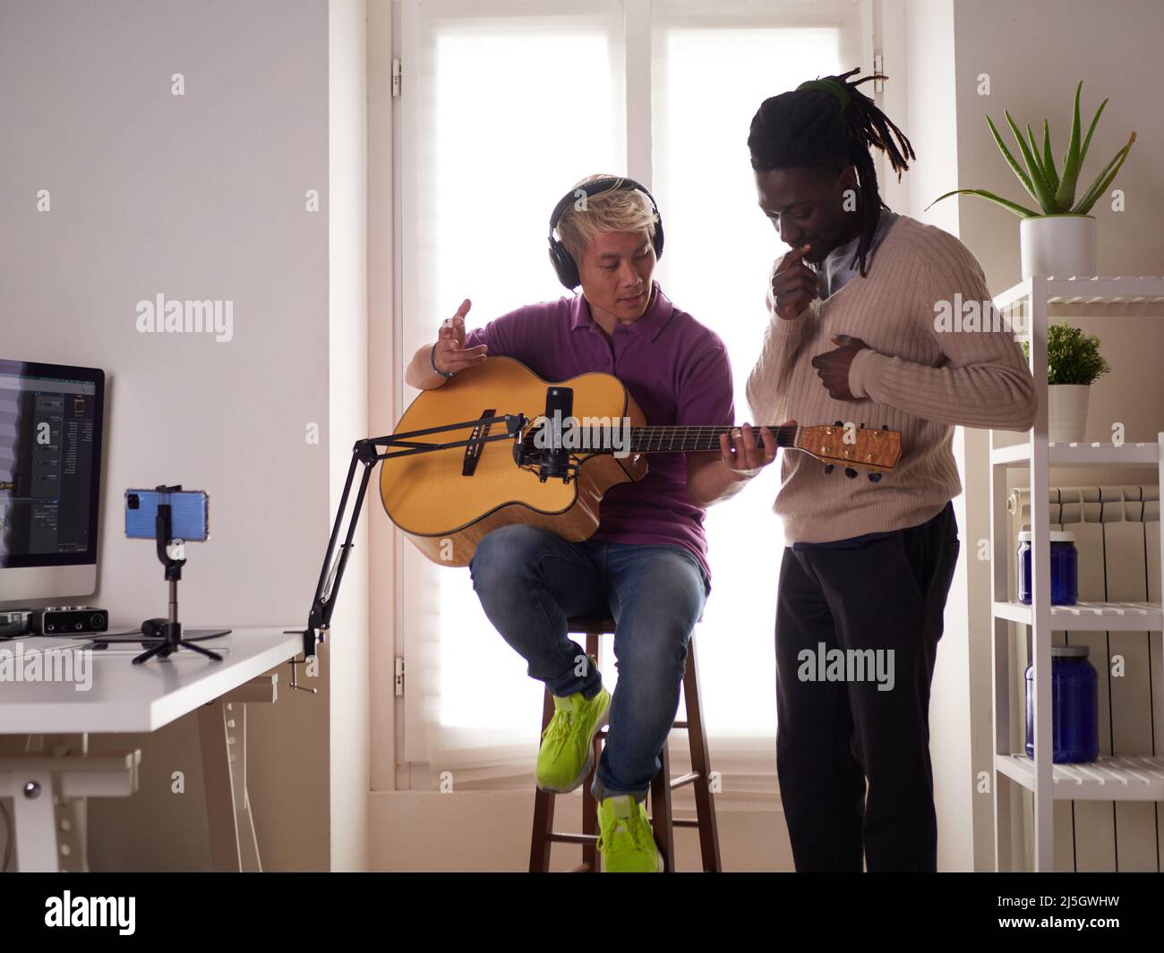 A personal afroamerican tutor explains to his asian student how to play ...