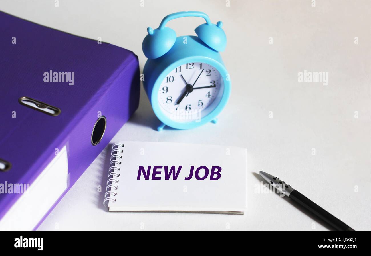 New job, text on notepad on white background with folder, clock and pen ...