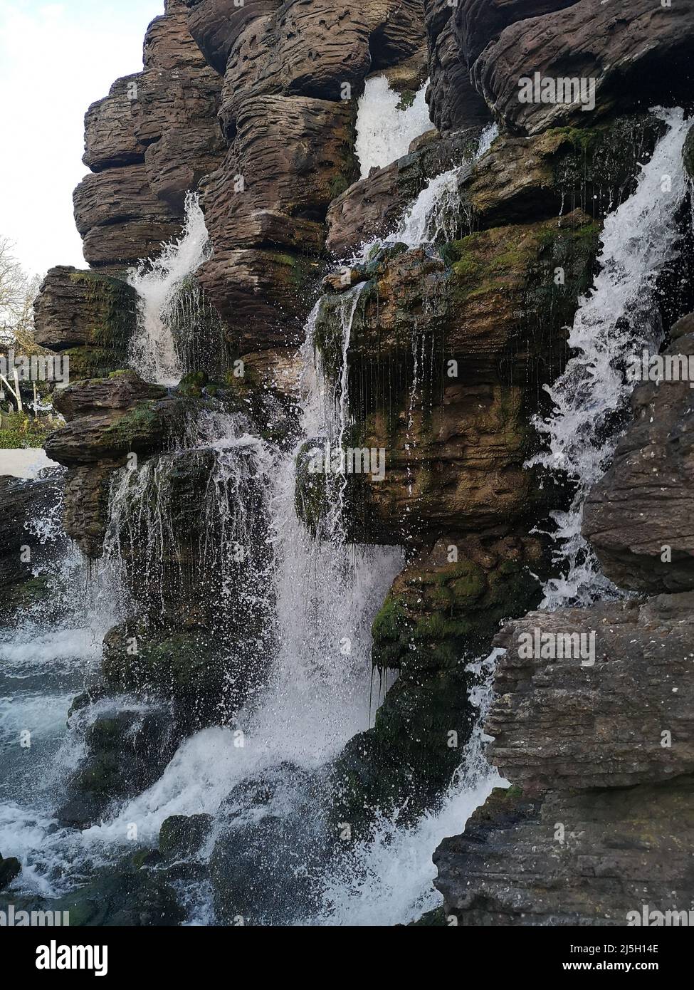 A view of an ornamental waterfall with several cascades tumbling over a ...