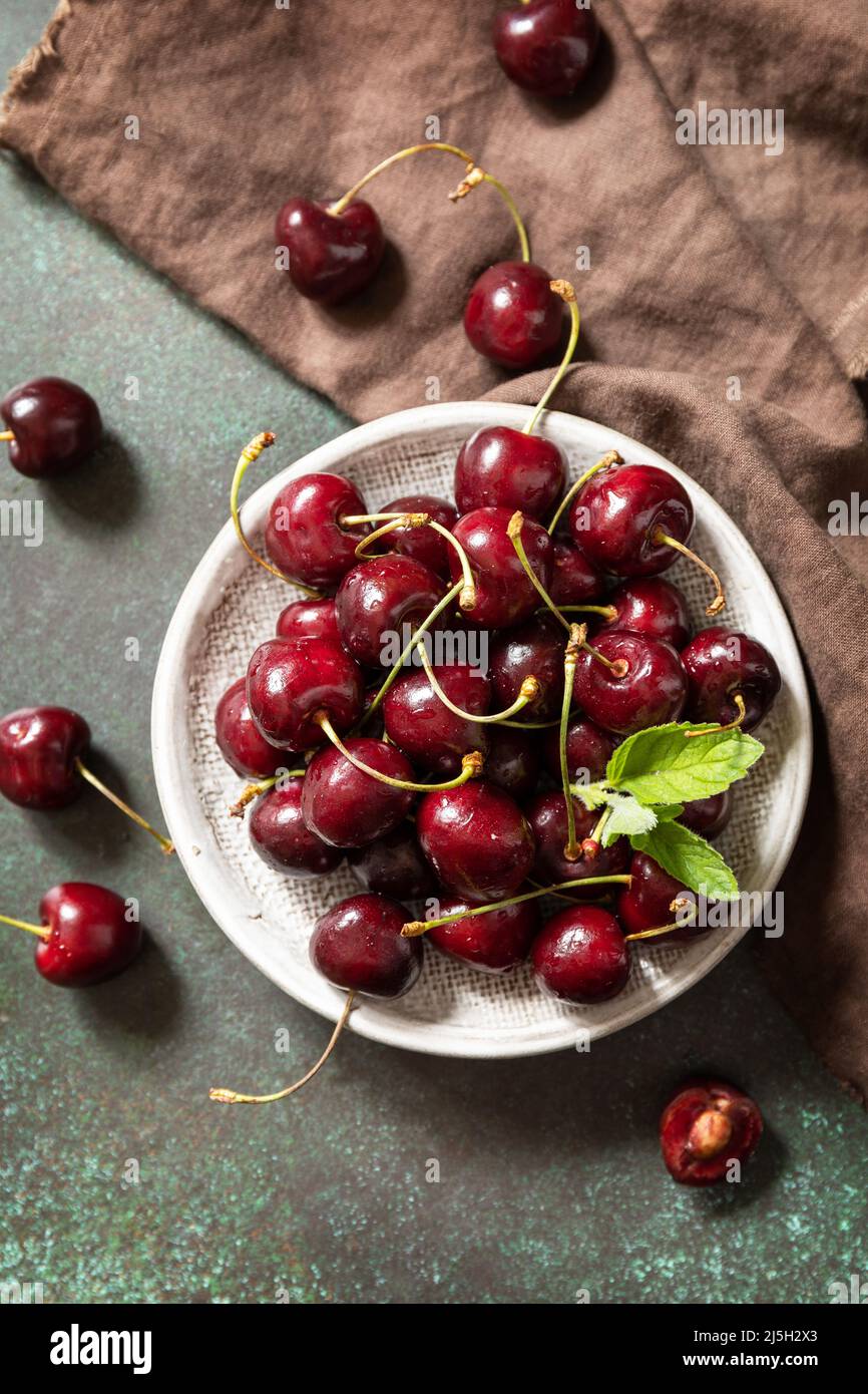Fresh ripe organic berry red sweet cherries on plate on a dark stone ...