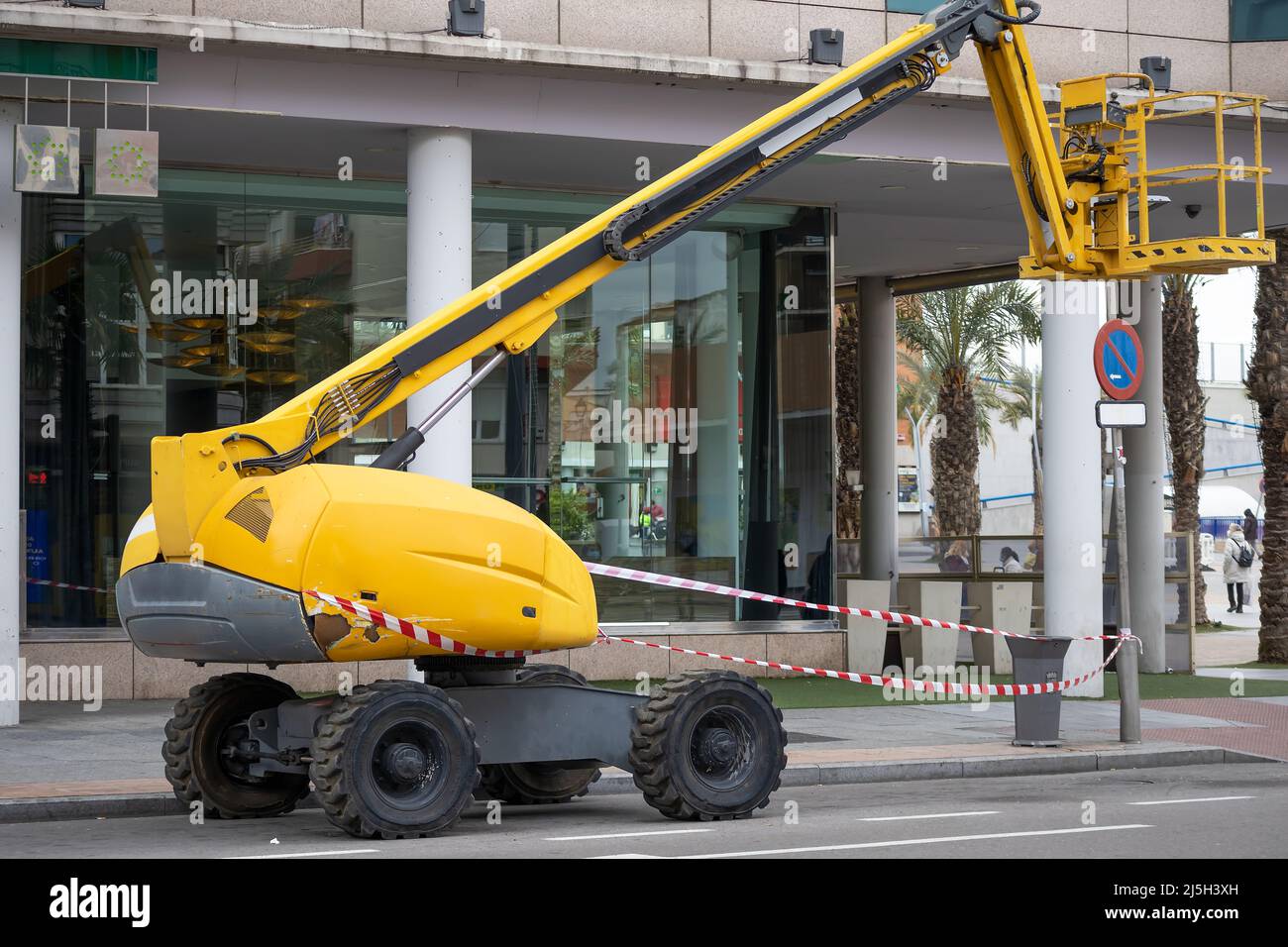closeup in horizontal view of an articulated boom lift of yellow color ...