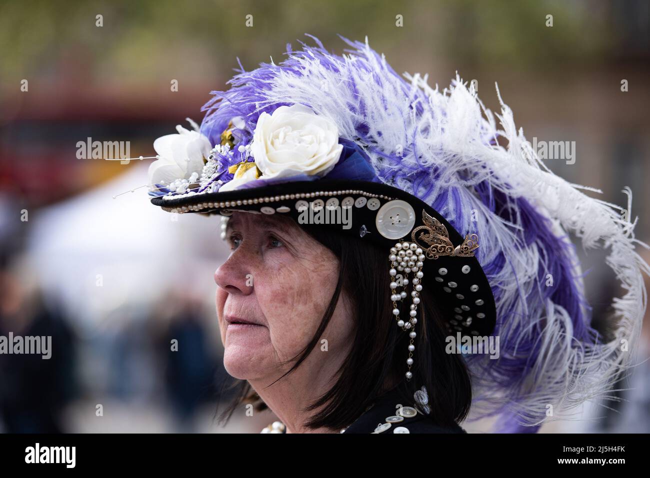 A reveler wears an ornate feather hat celebrating St George's Day. St ...