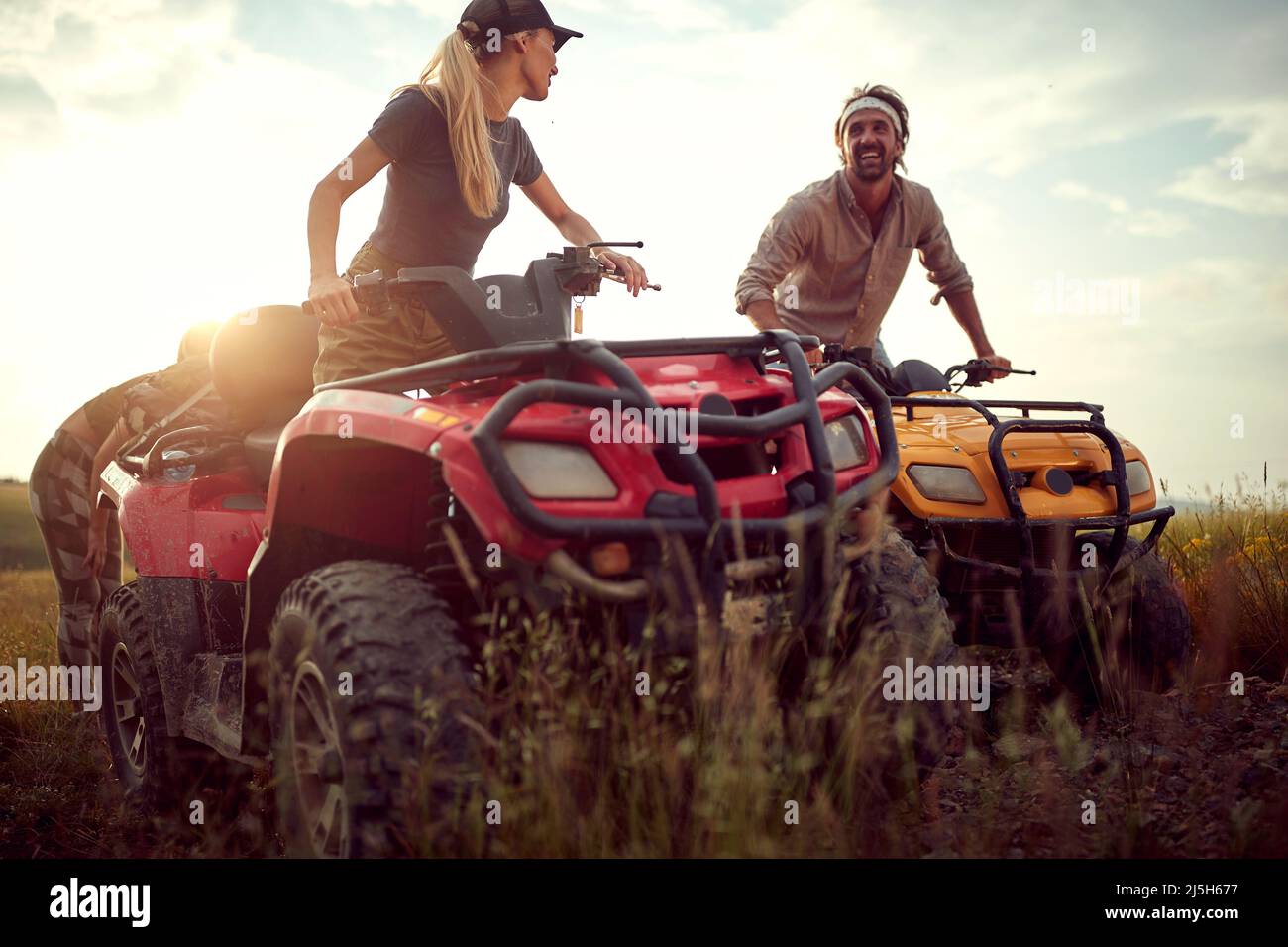 Two good friends driving quads together in the nature; Active vacation ...