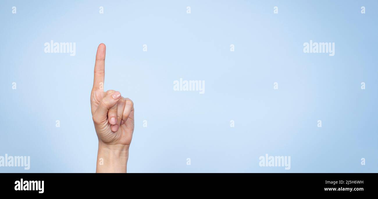 Hand gesture. Female hand shows number one. Woman pointing up with ...